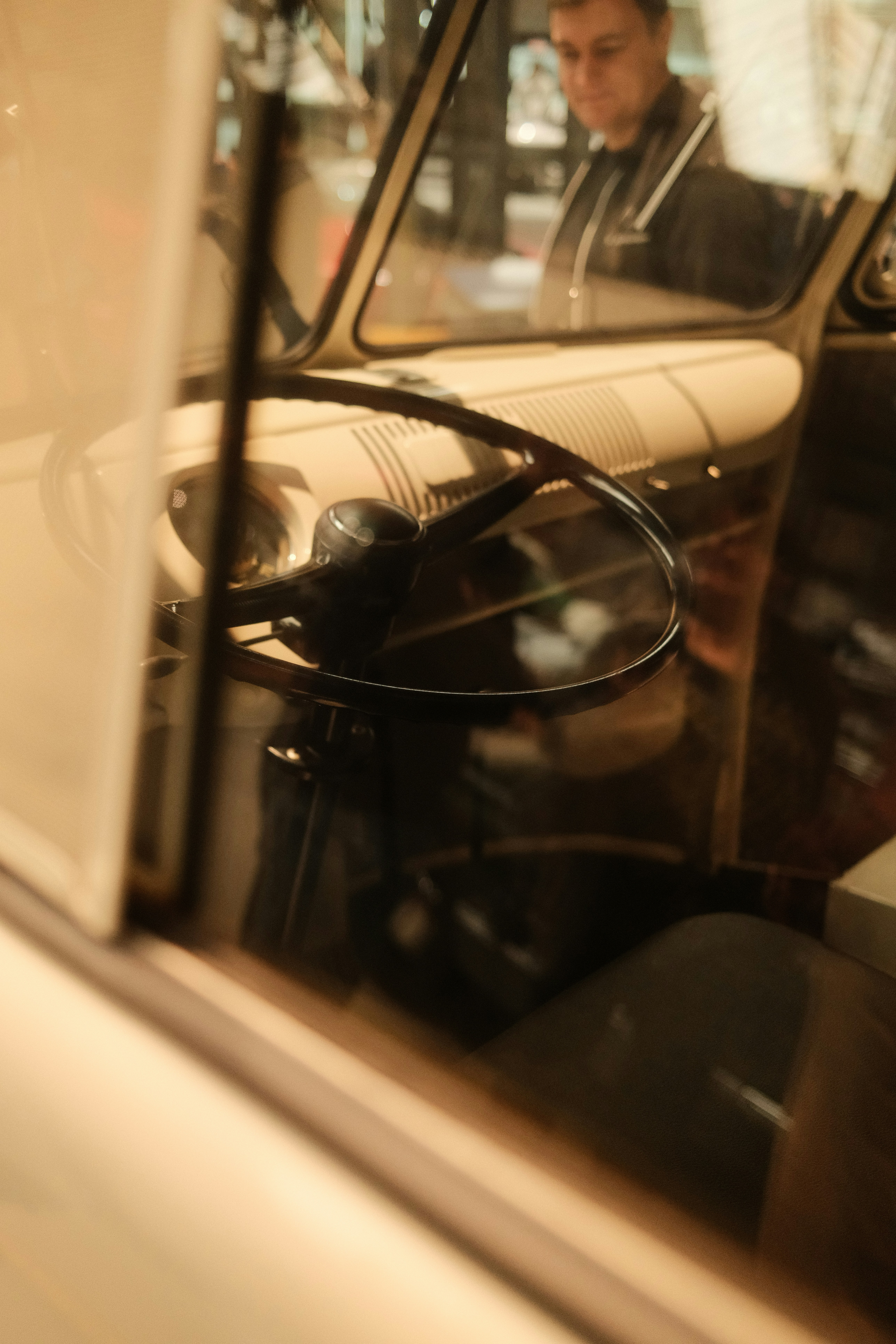 Vintage Car Interior Through Window: A Glimpse of the Steering Wheel and Dashboard