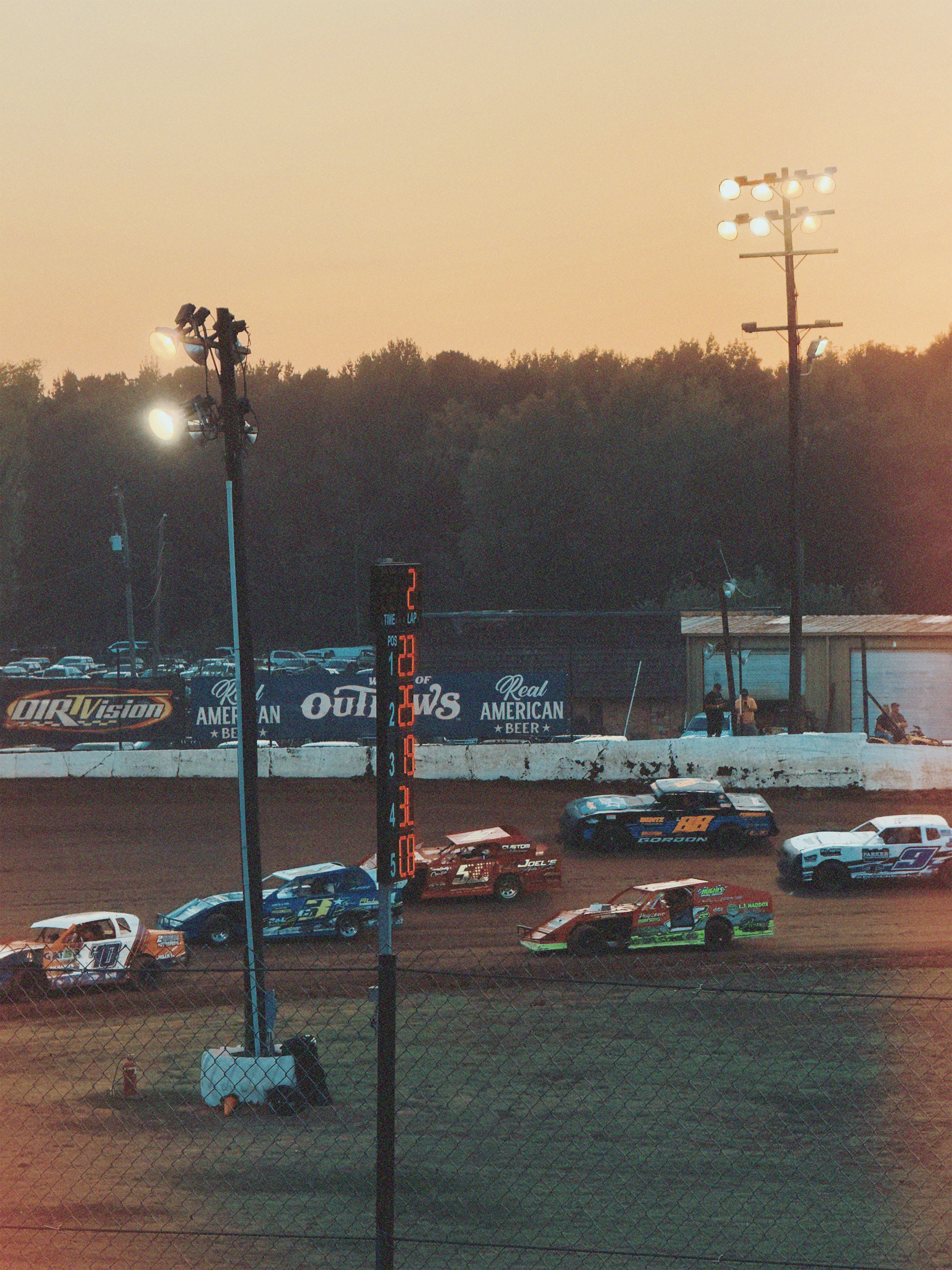 Evening Sprint: Cars Race Under Stadium Lights