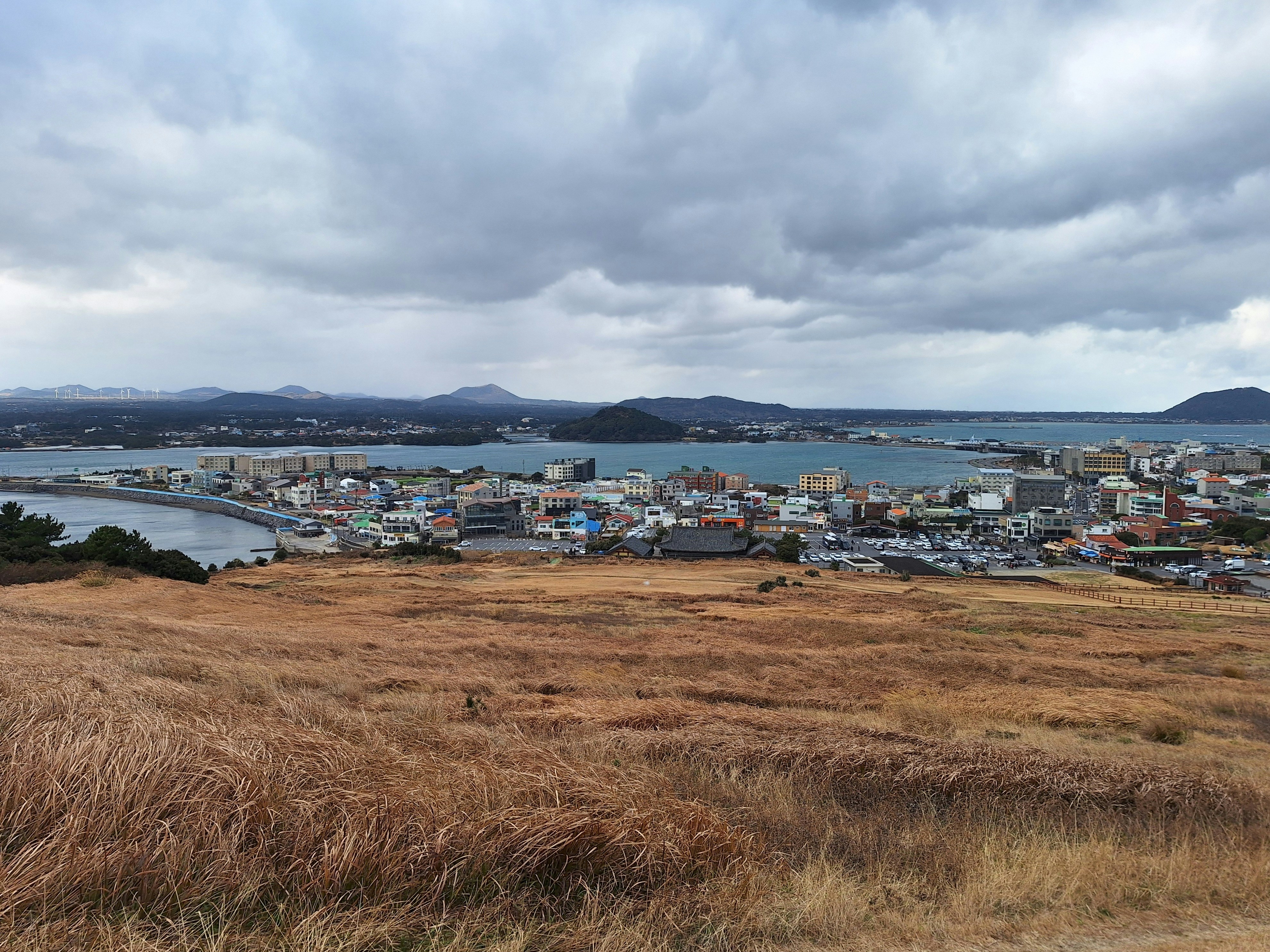 Horizon of Homes: Coastal Town Beneath Awe of Clouds