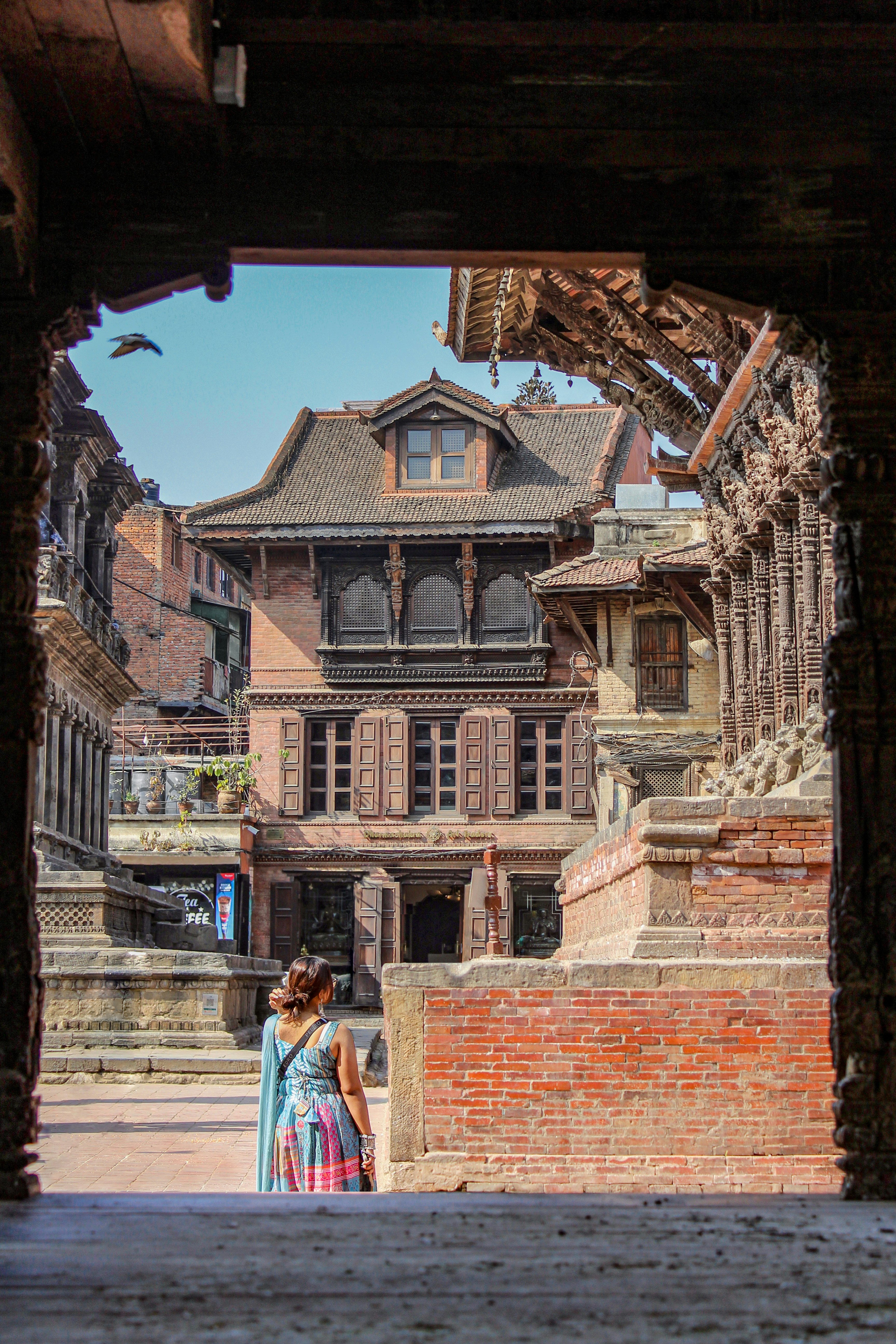 Traveler in a Walled Courtyard Framed by Historic Carved Archway