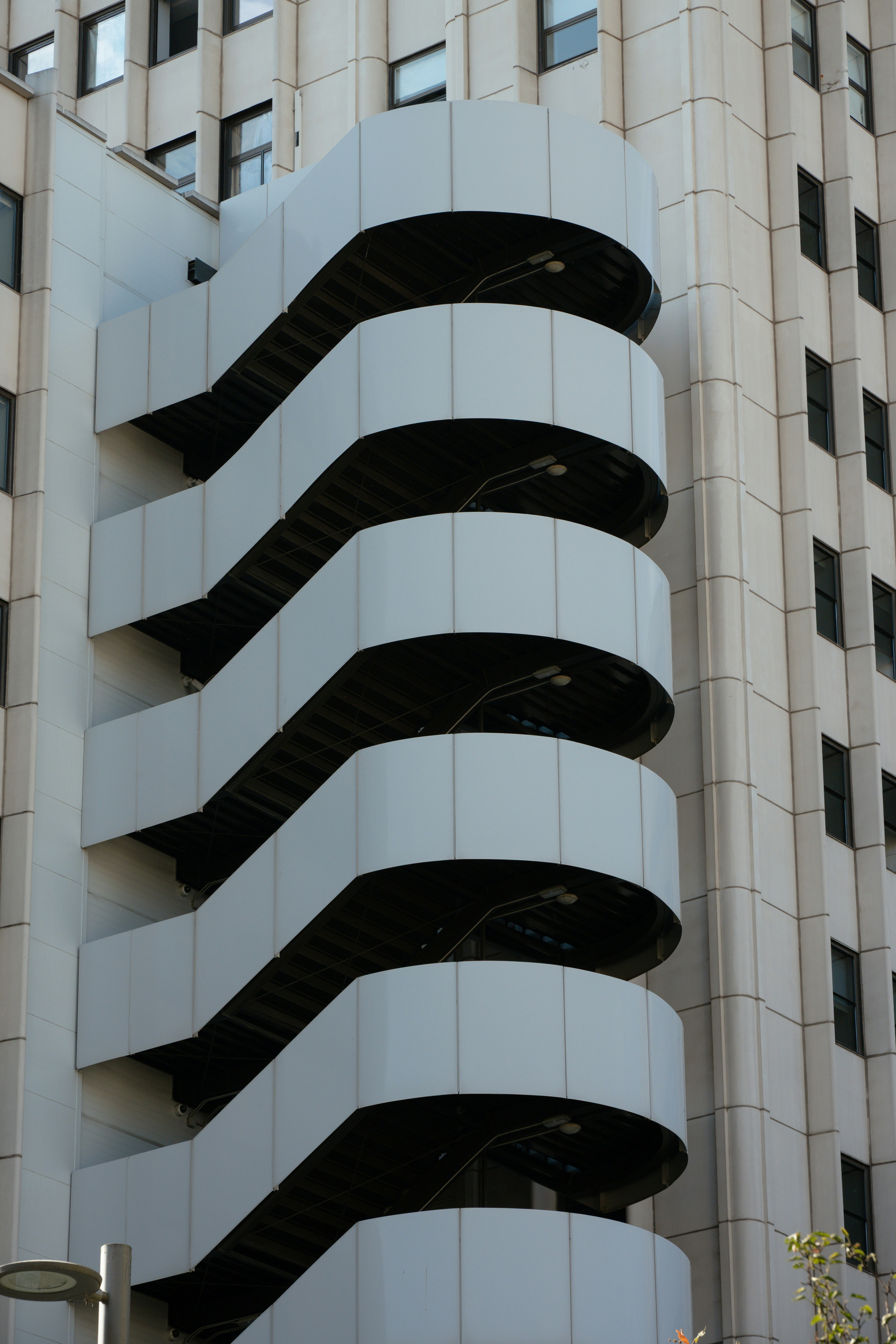 Architectural Spirals: The White Staircases Climbing a Concrete Facade