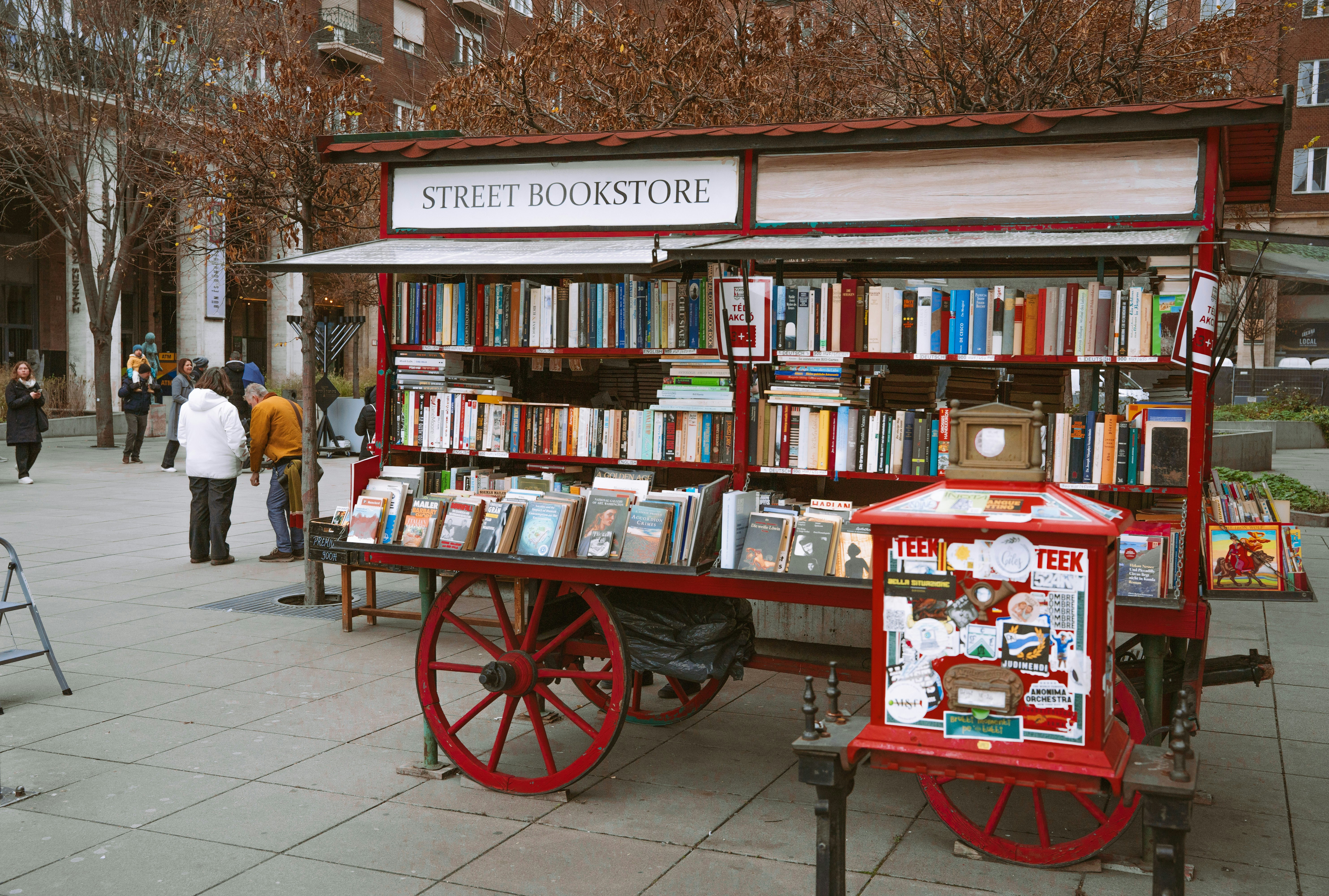 Red-Wheel Book Cart on a Quiet City Arcade