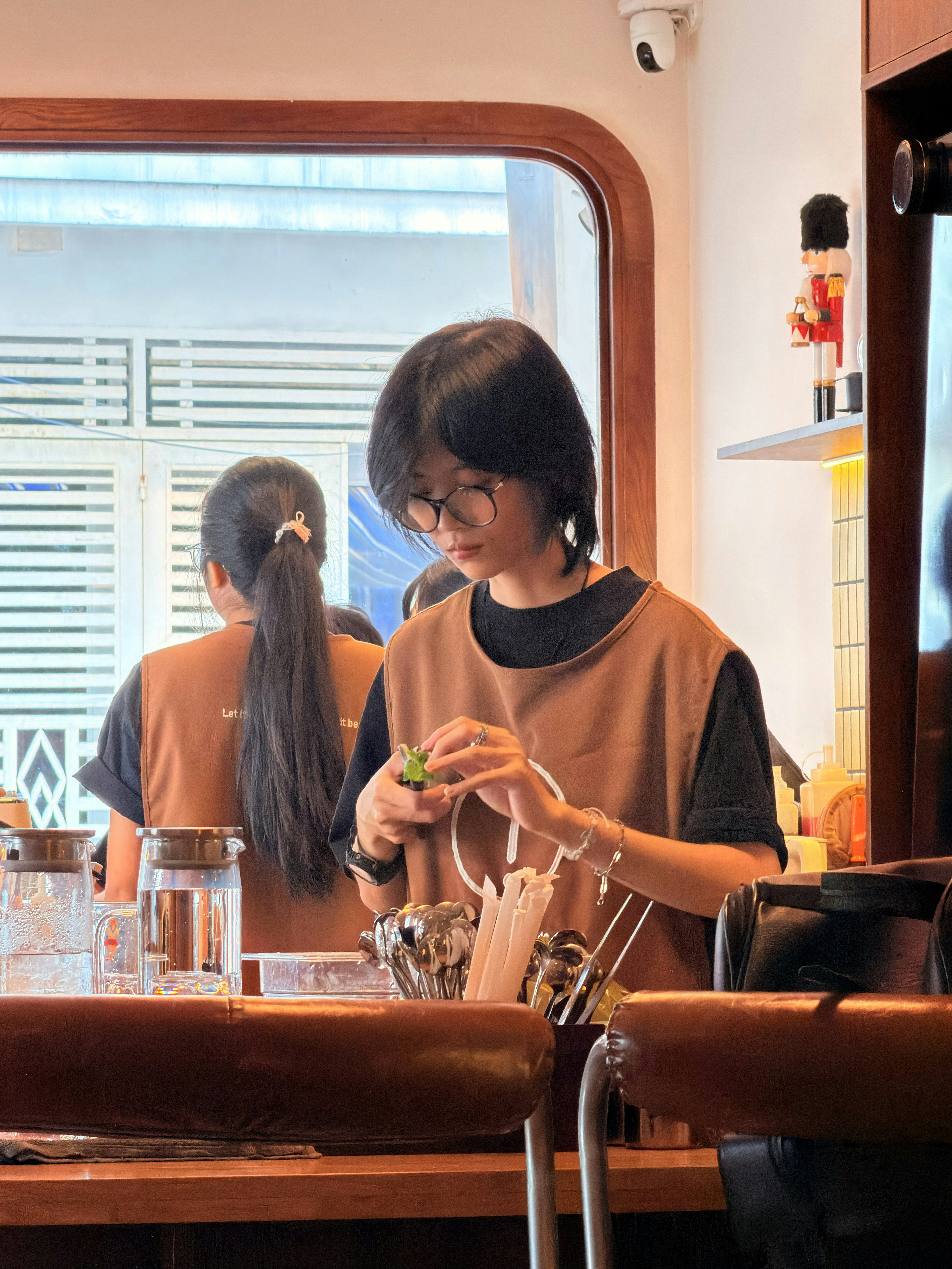 Focused Craft: A Barista at Work with Green Toy in Hand