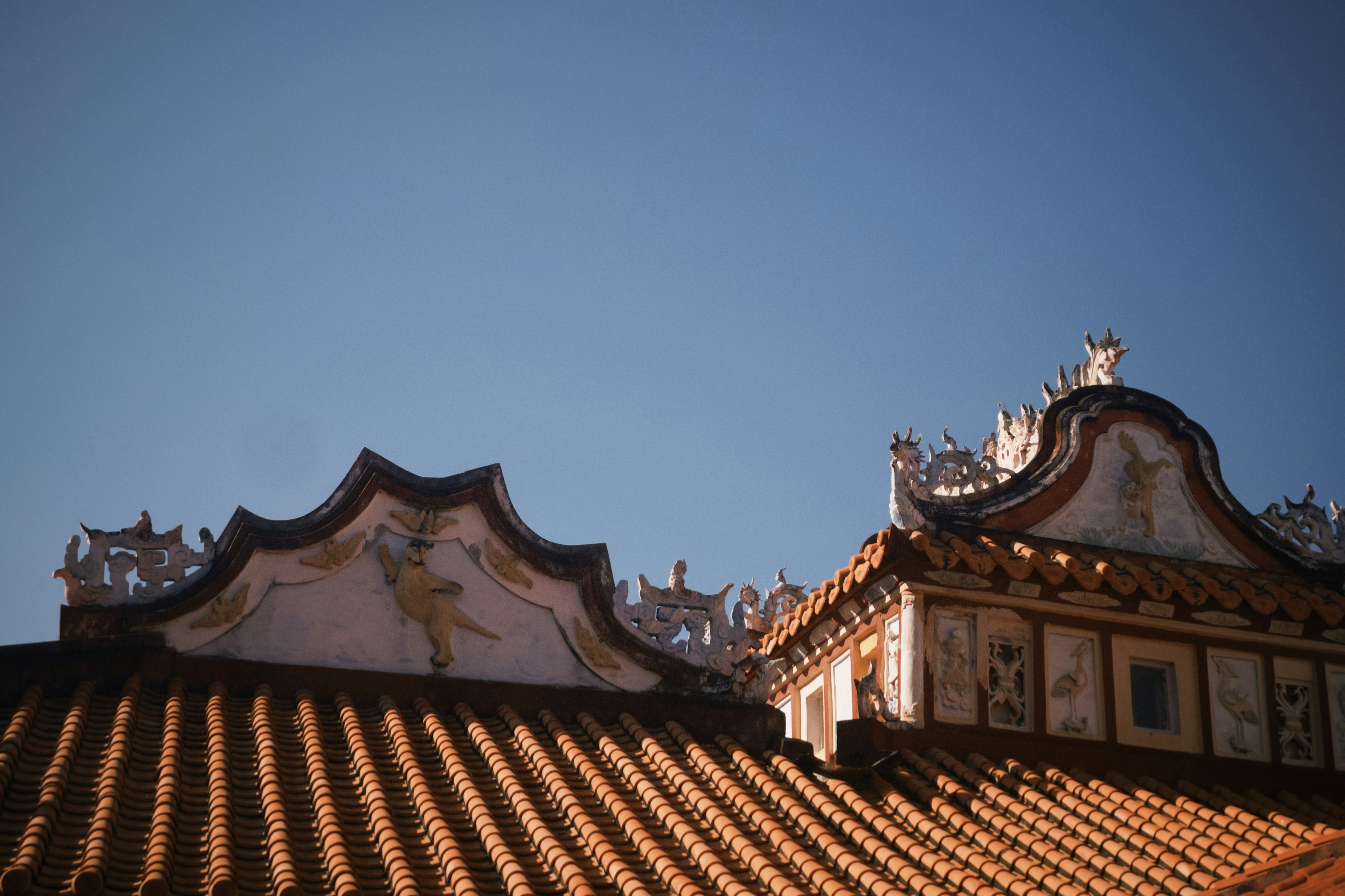 Sunlit Shaped Tiles: A Close View of Ornate Roof Lines