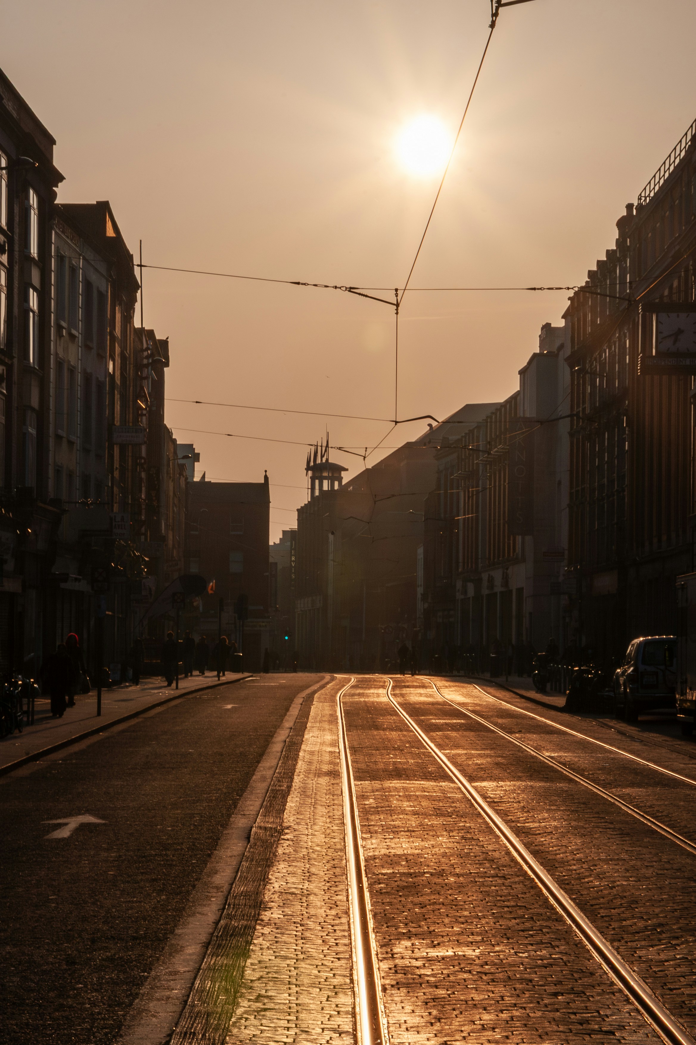 Sunlit Tram Tracks Down a Cobblestone Street