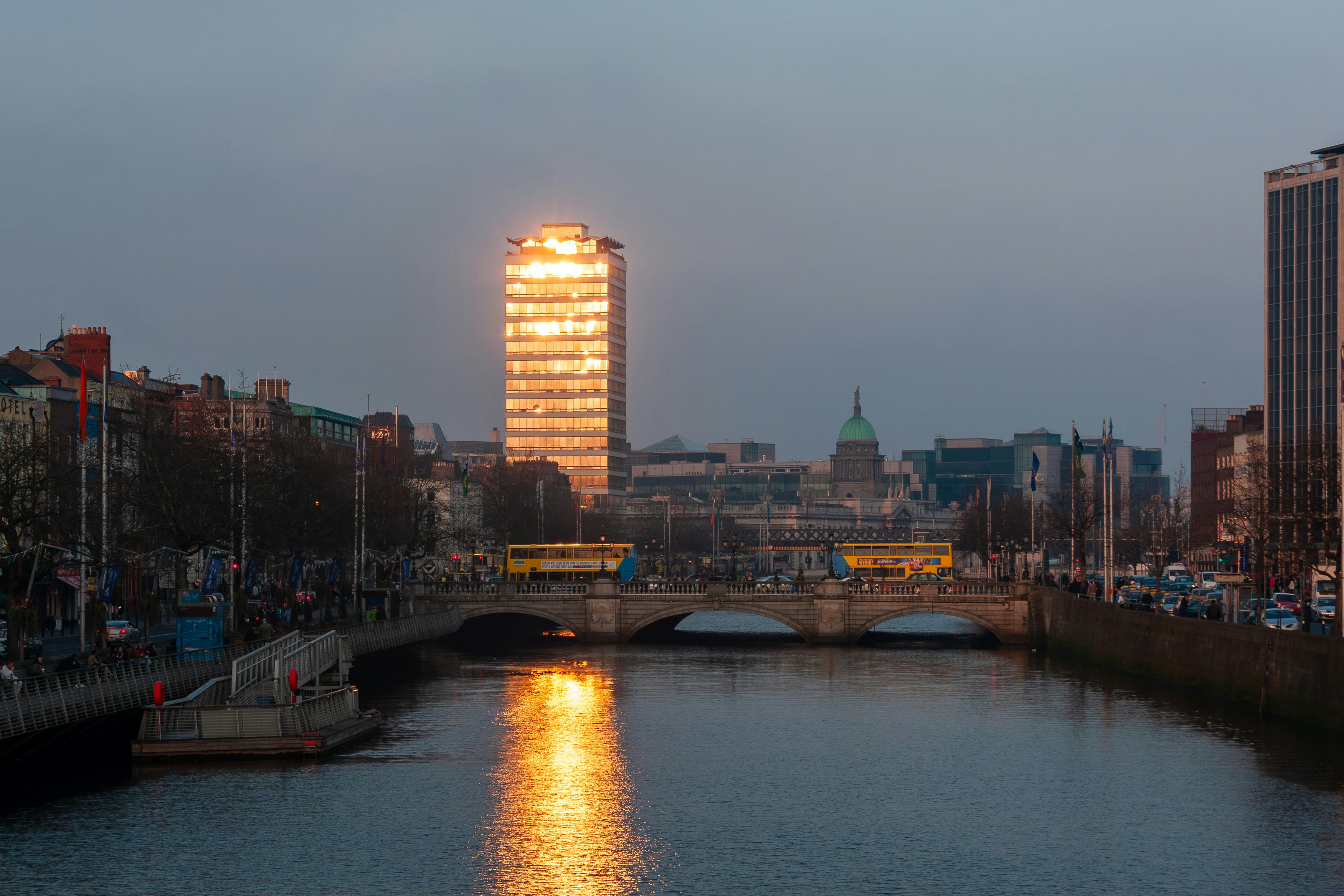 Sunlit Skyscraper Over the Liffey: Evening Reflections on the River