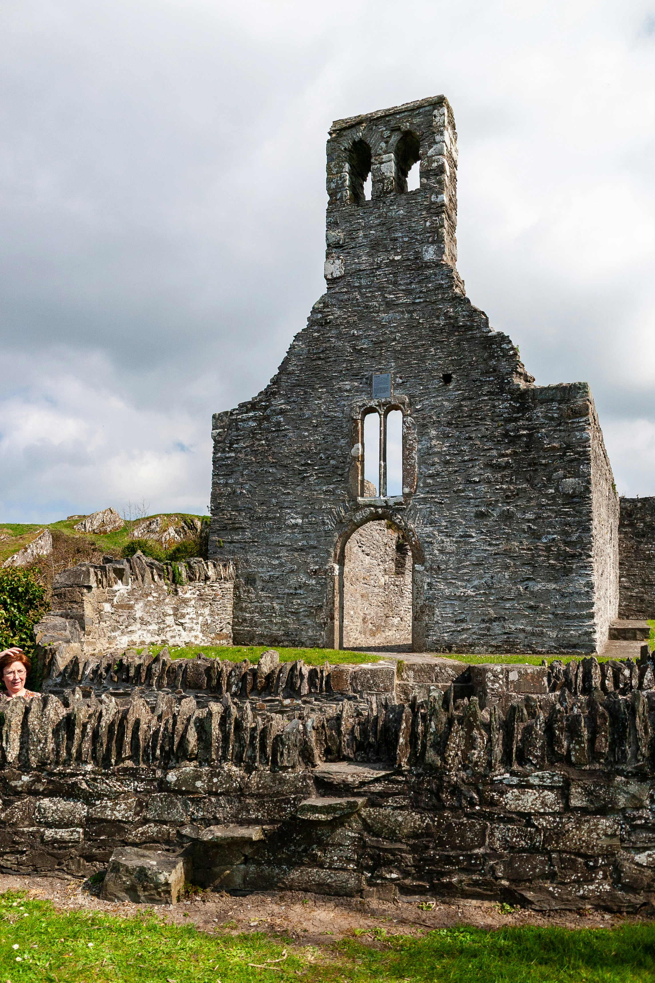Ruined Stone Chapel Rising from Mossy Terraces Under a Brooding Sky