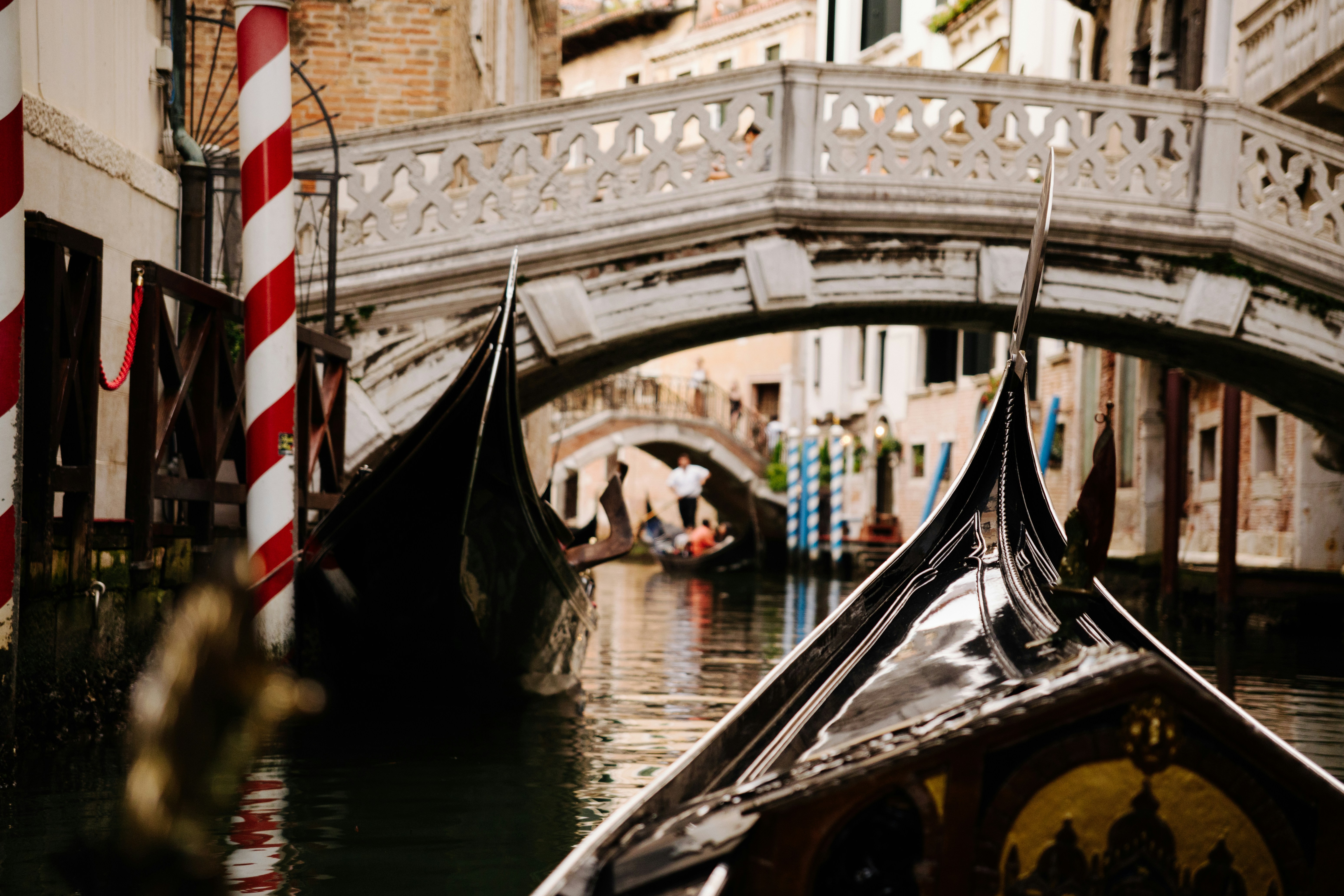 Gondolas Under the Stone Bridge in a Venetian Canal