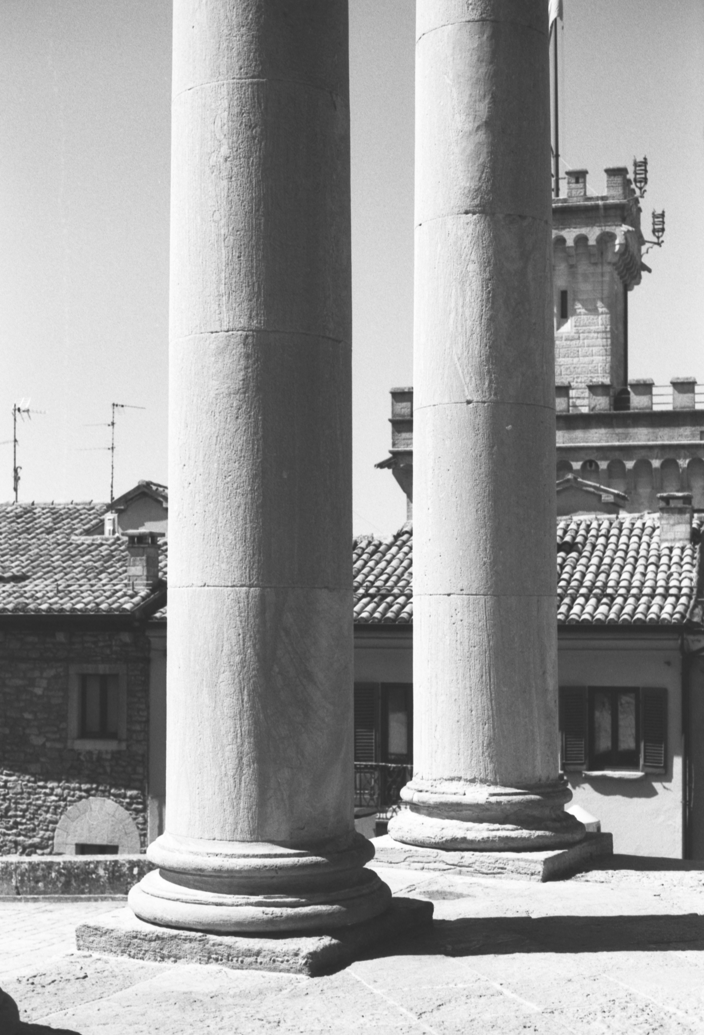 Two large columns in front of old buildings