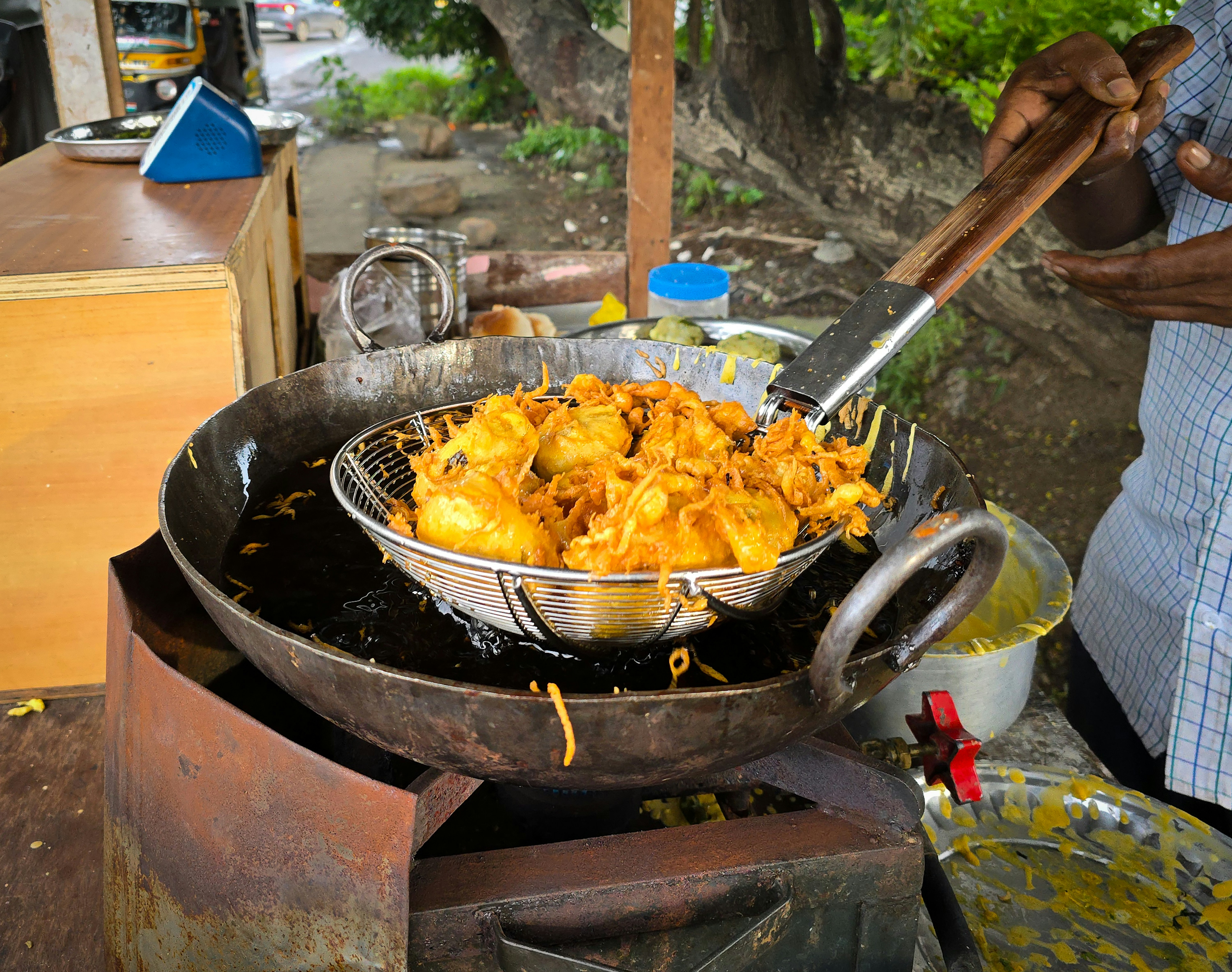 Freyendo pakoras en un wok grande en un carrito callejero. foto ...