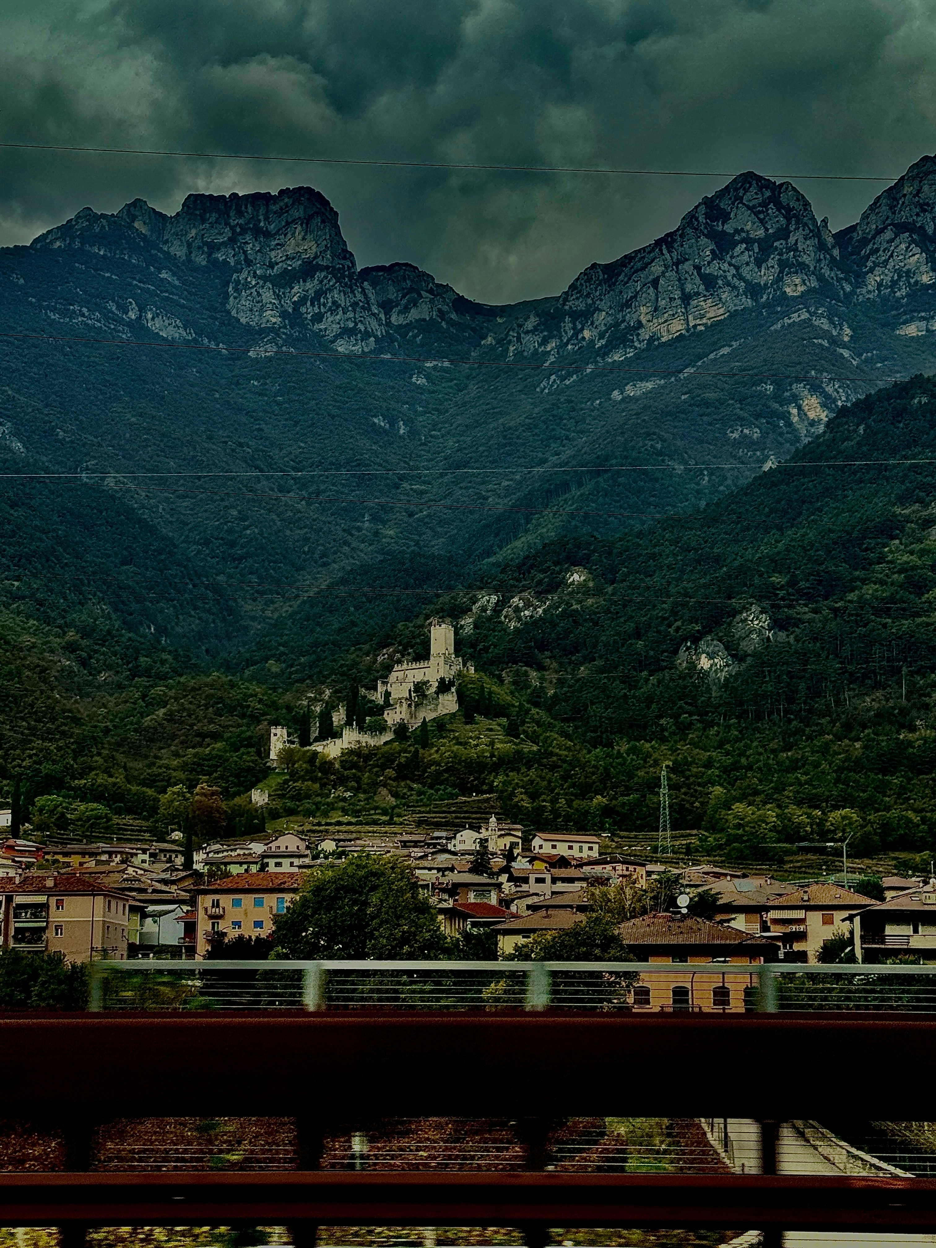 Castle on the Green Slope: A Mountain Village Under Dark Skies
