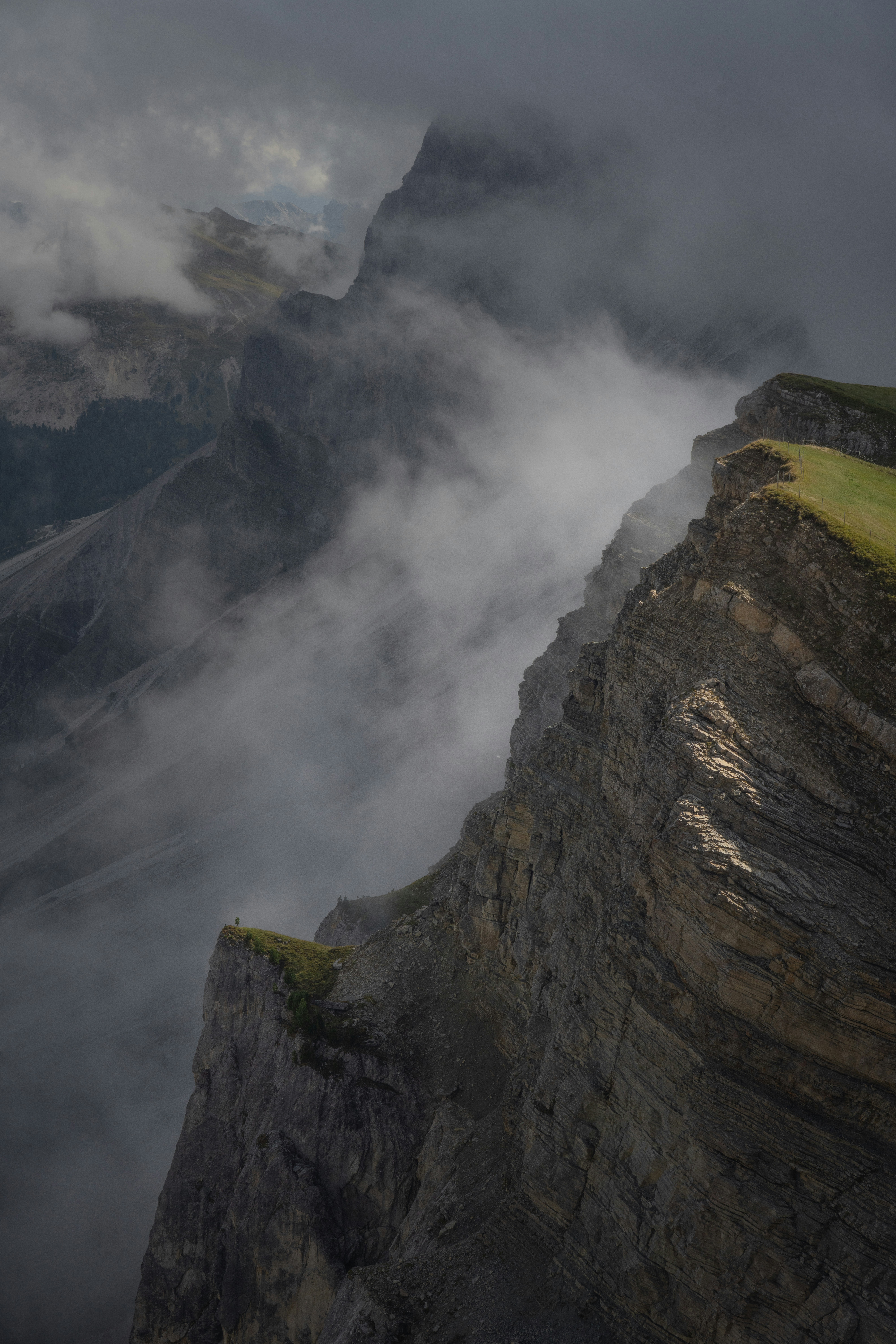 Montañas brumosas con formaciones rocosas espectaculares y hierba verde ...
