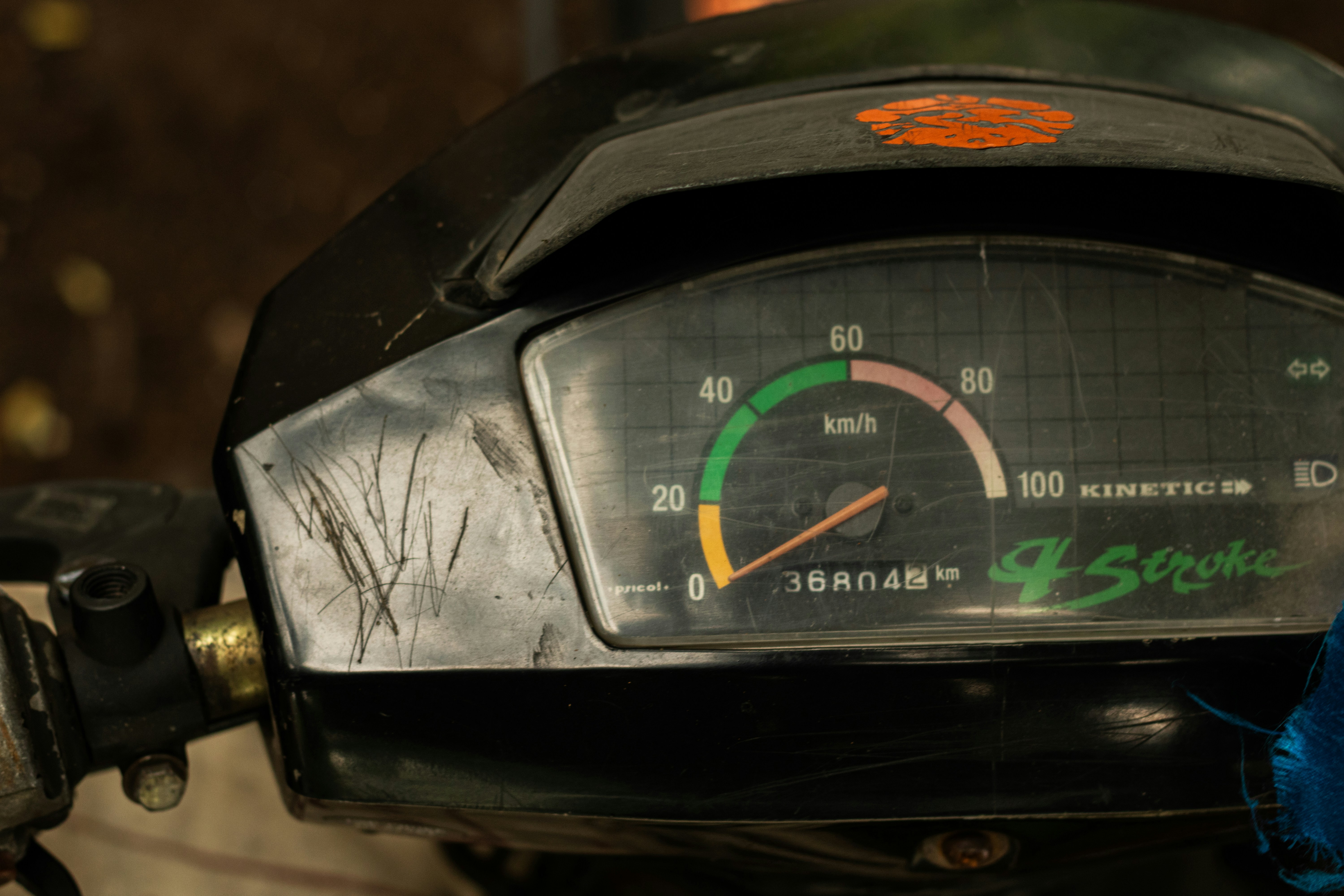 Worn Speedometer of a Motorcycle: Cracks, Dust, and a Silent Indicator
