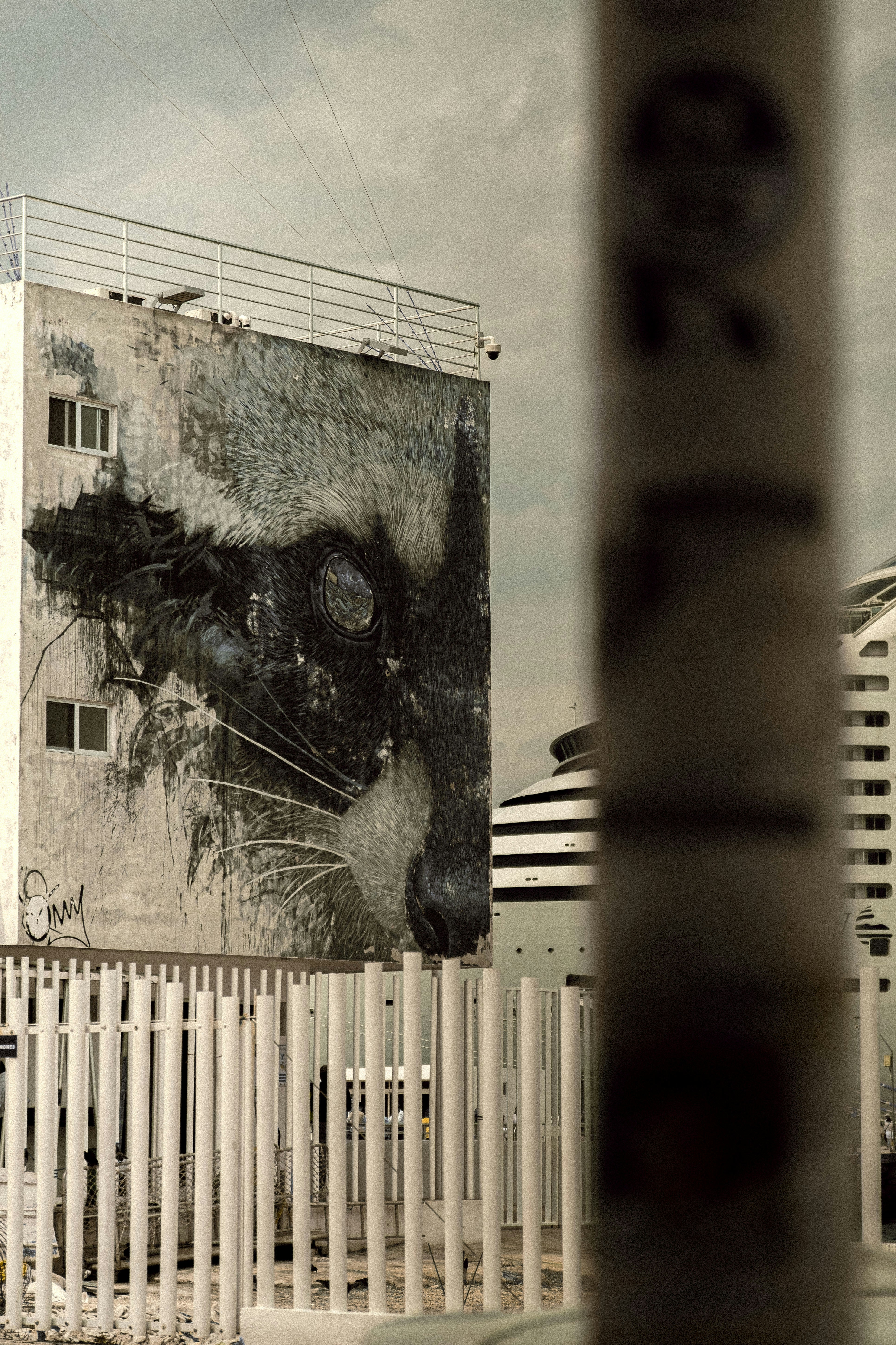 Urban mural of a cat merging into an industrial skyline