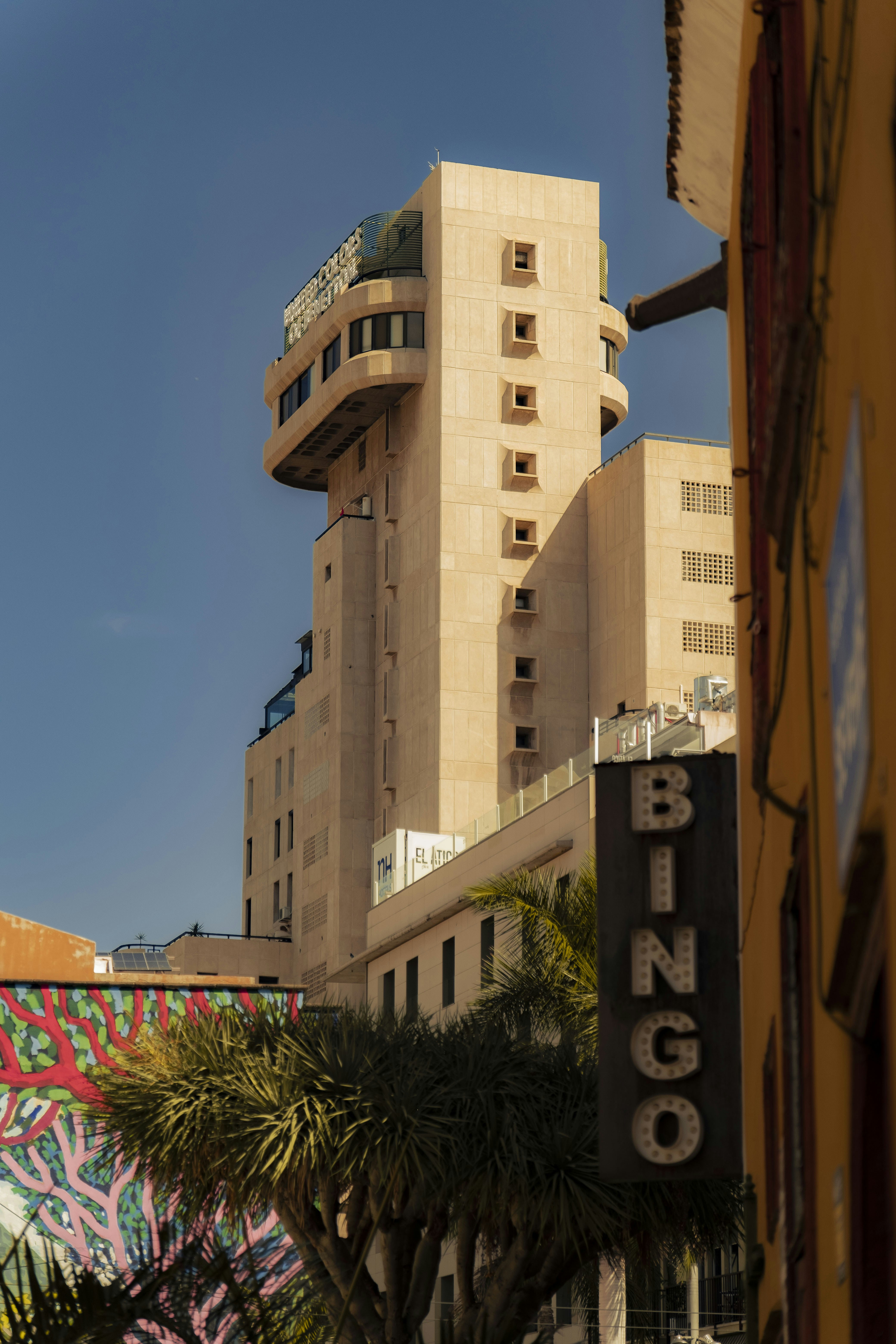 Vertical Cityscape: The Curved Corner Tower Rising Above a Colorful Street