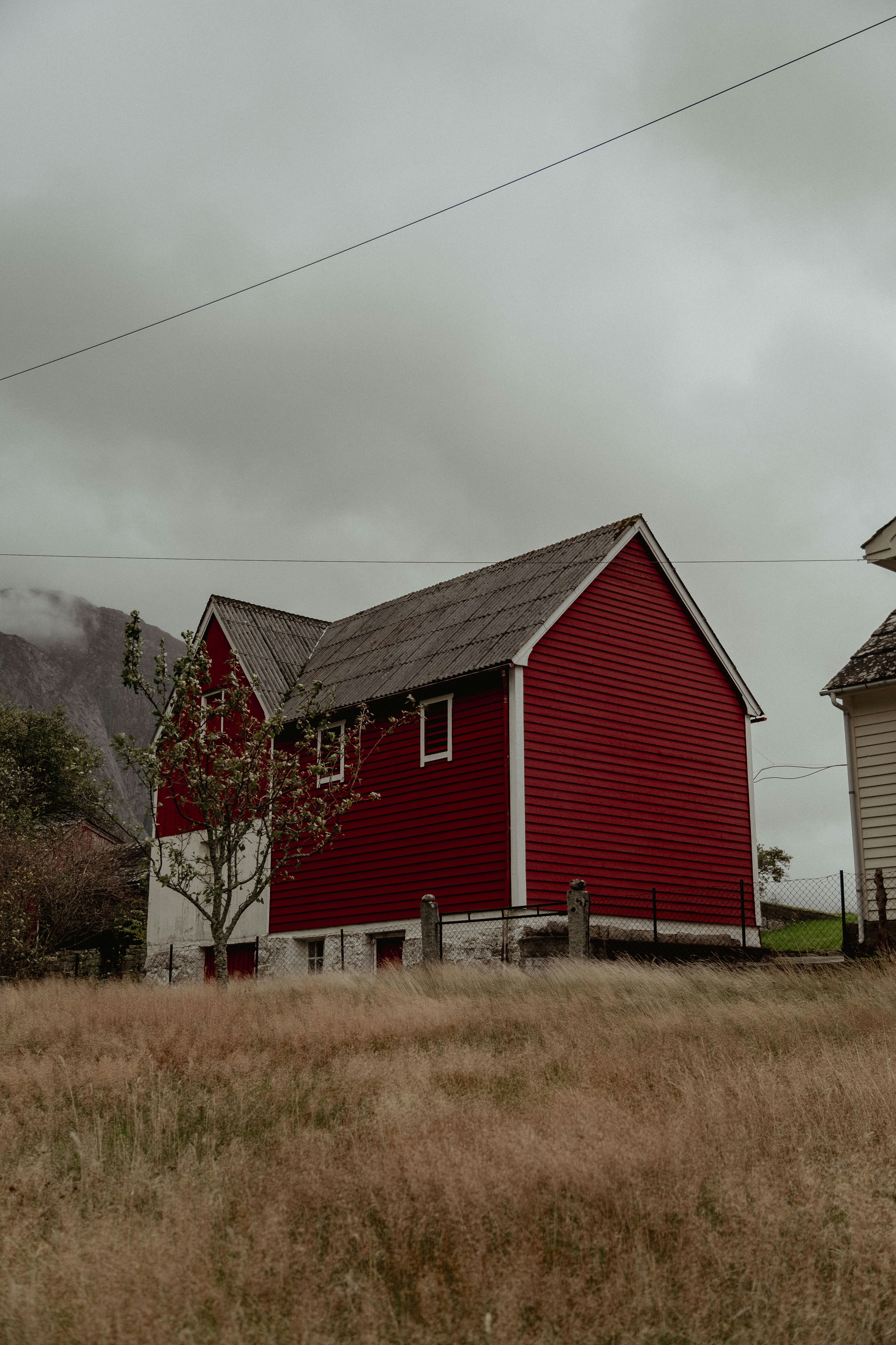 Red Cottage in Gentle Hill: A Quiet Countryside Scene Under Overcast Skies
