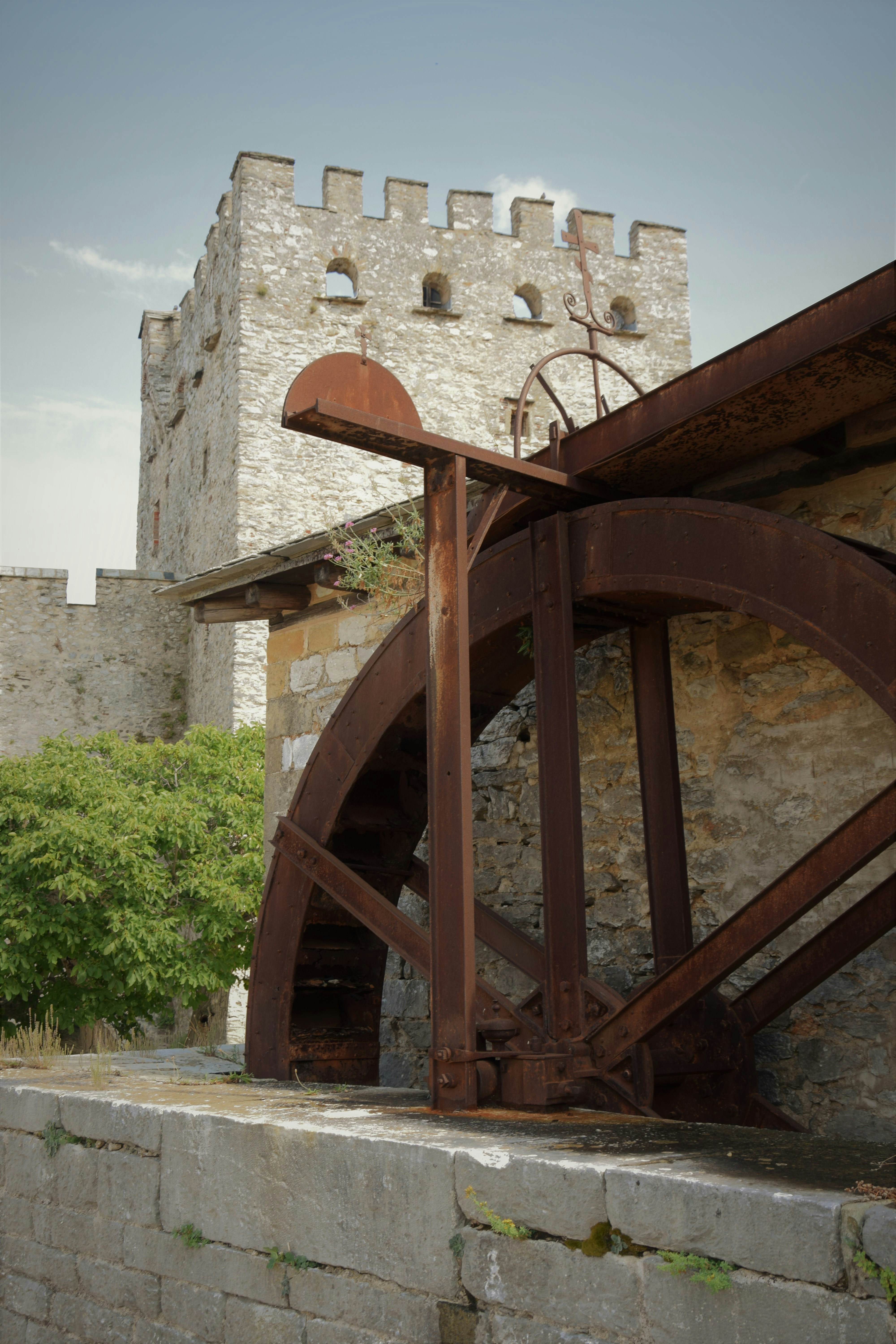 Rust and Relic: A Windmill Wheel Before the Castle Tower