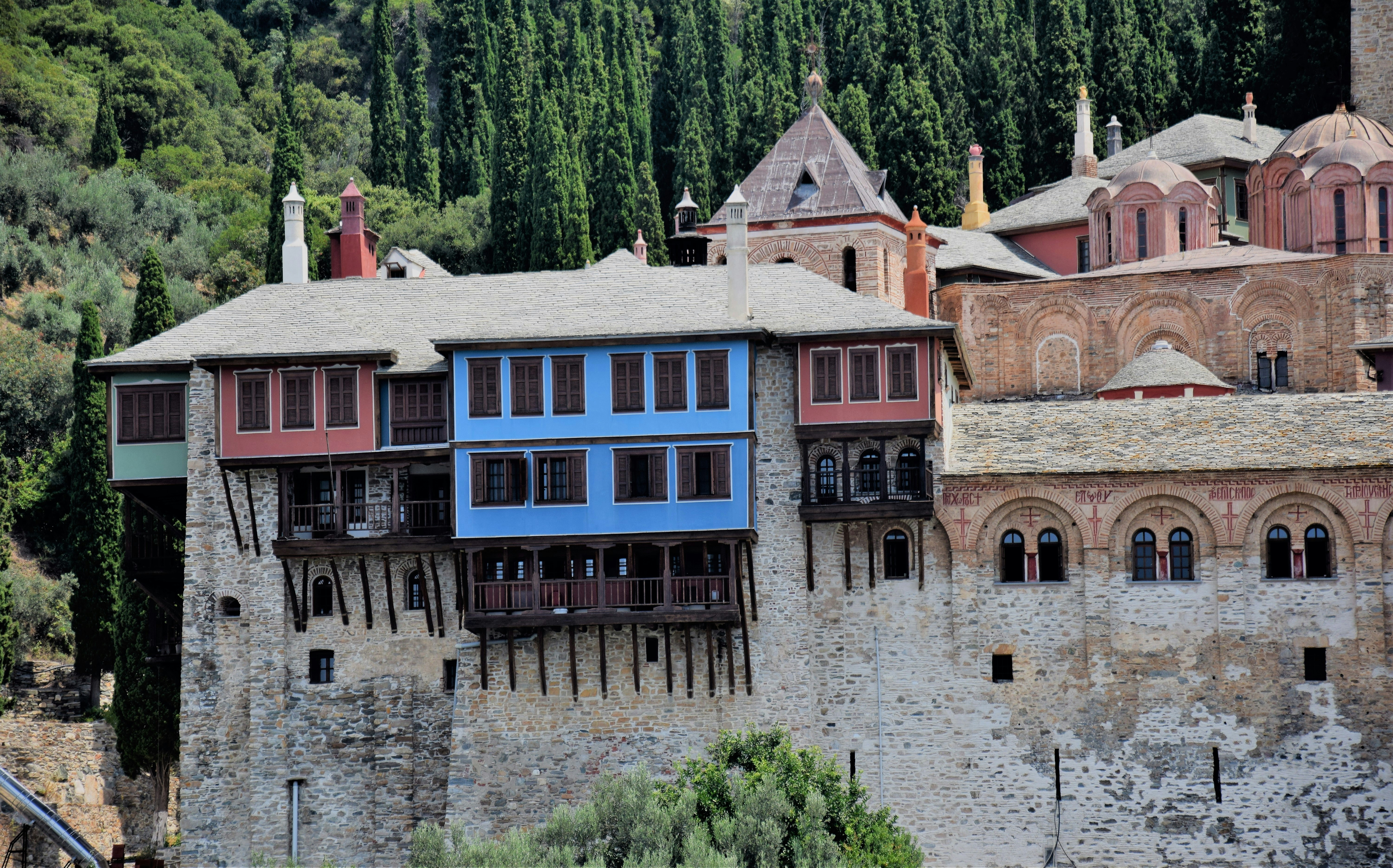 Colorful houses clinging to a fortress wall above a lush valley