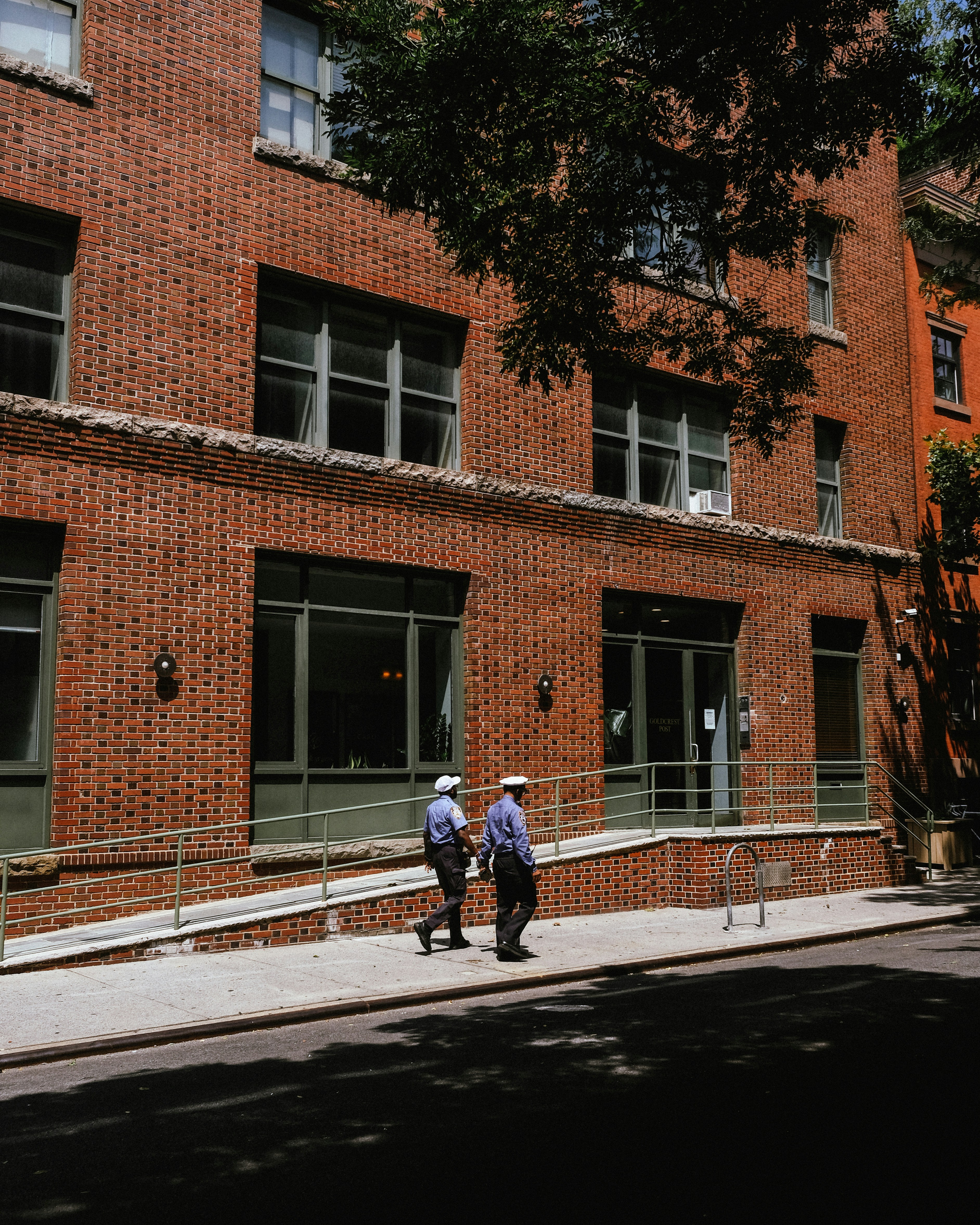 Pedestrians in front of a brick industrial facade