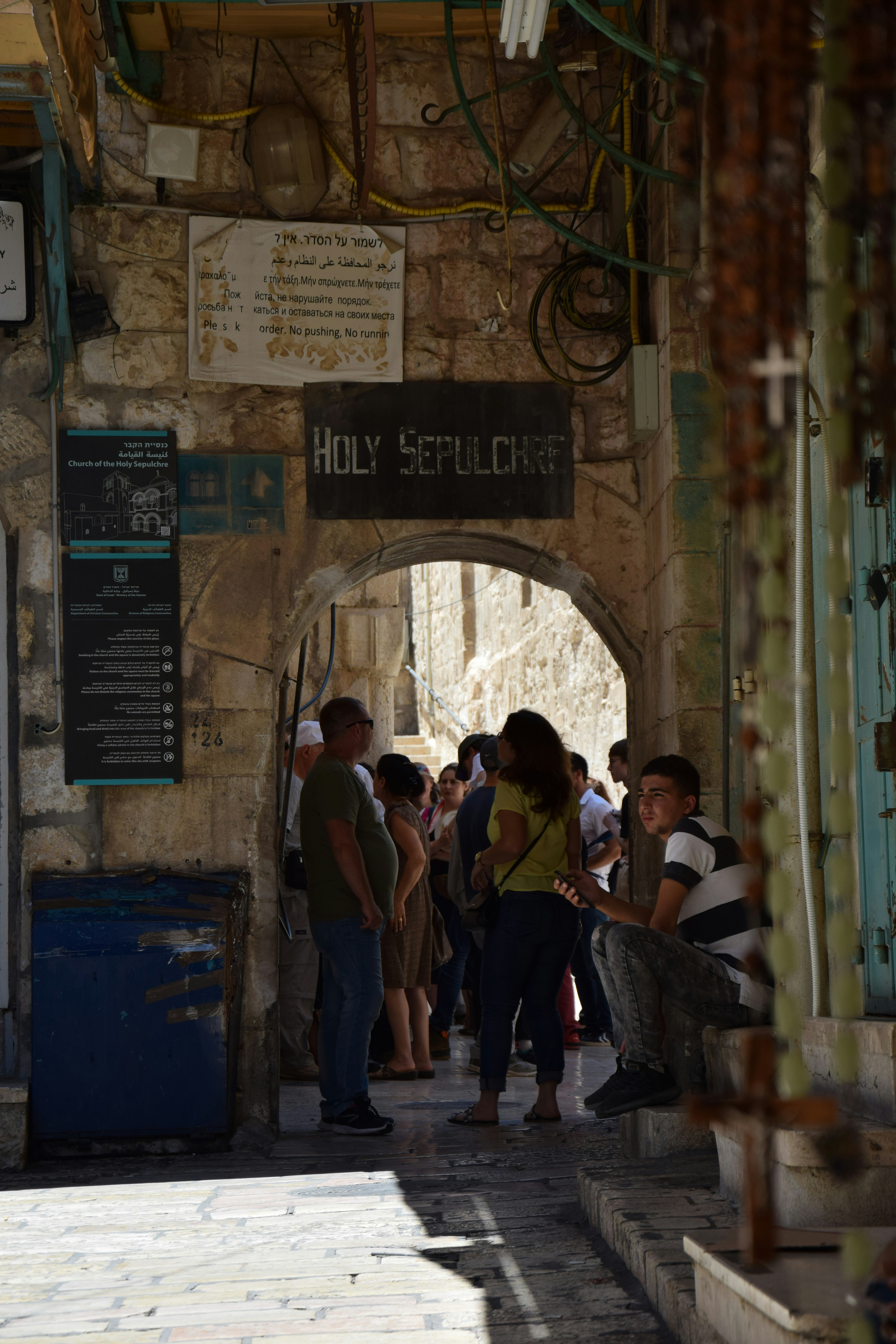 Stone Archway and Gathered Tourists at Holy Sepulchre Entrance