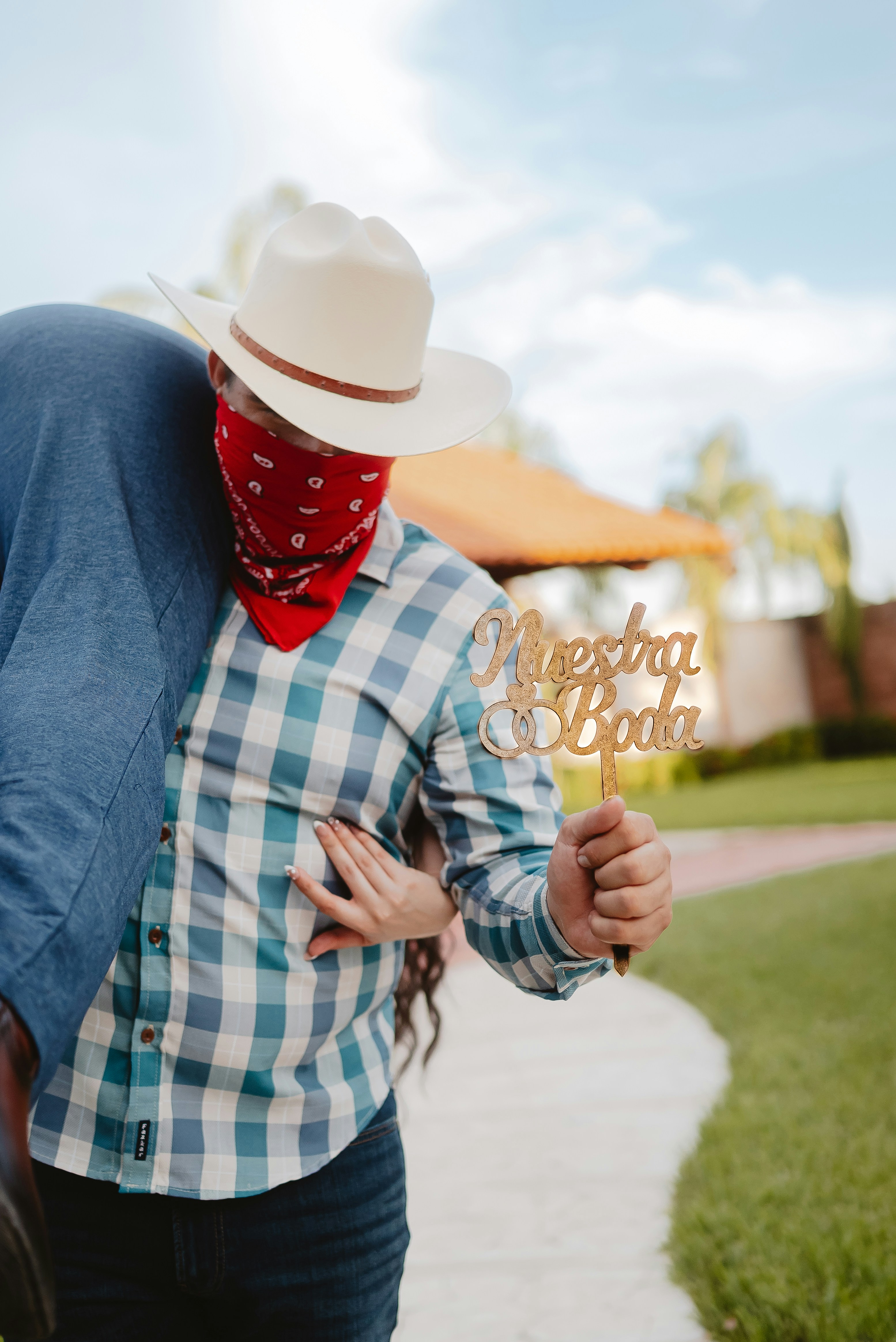 Masked Cowboy Moment: Holding a Glimmering 'Muestra Vida' Sign at Golden Hour
