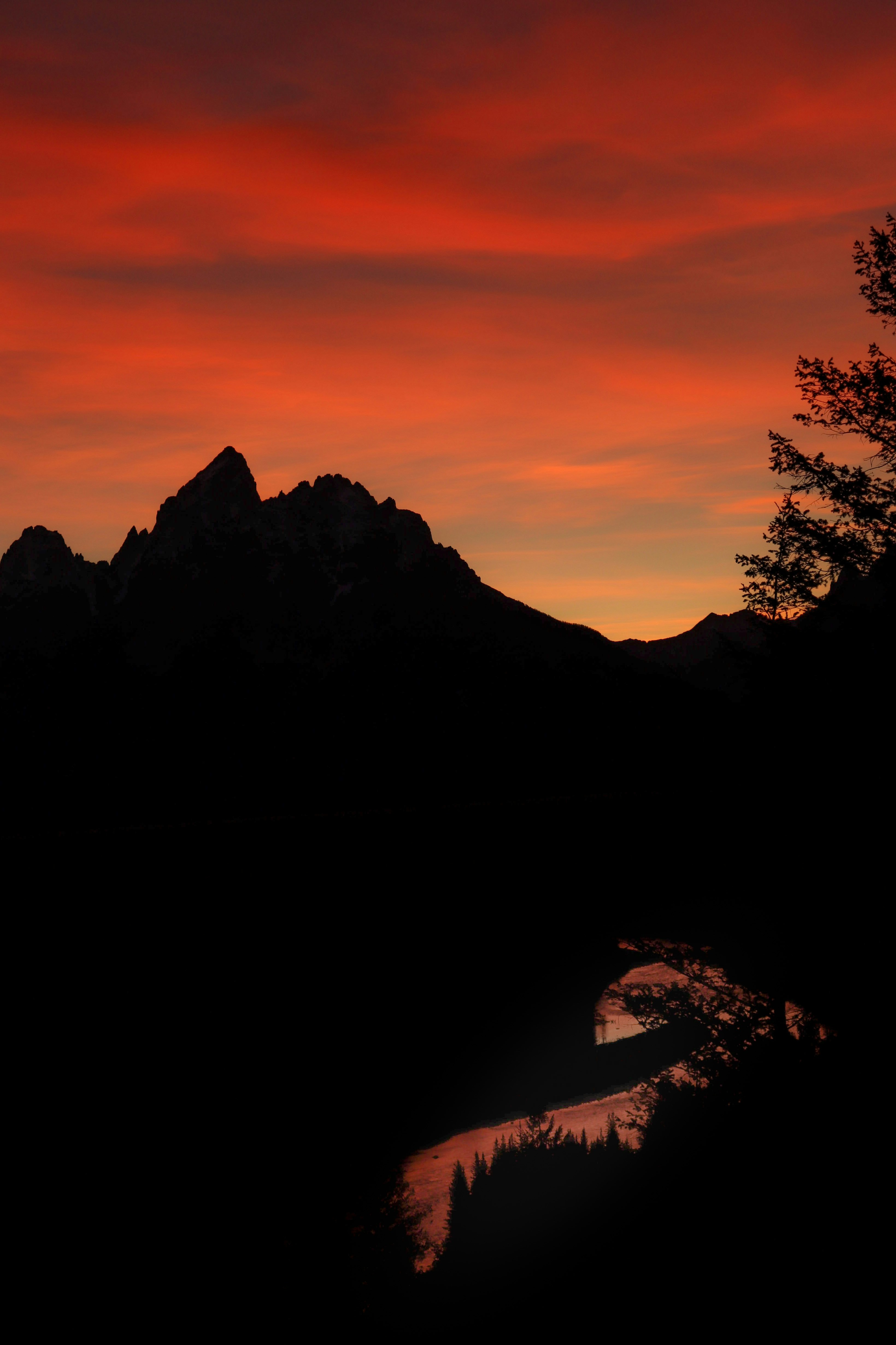 Puesta de sol dramática sobre picos montañosos y río recortados. foto ...