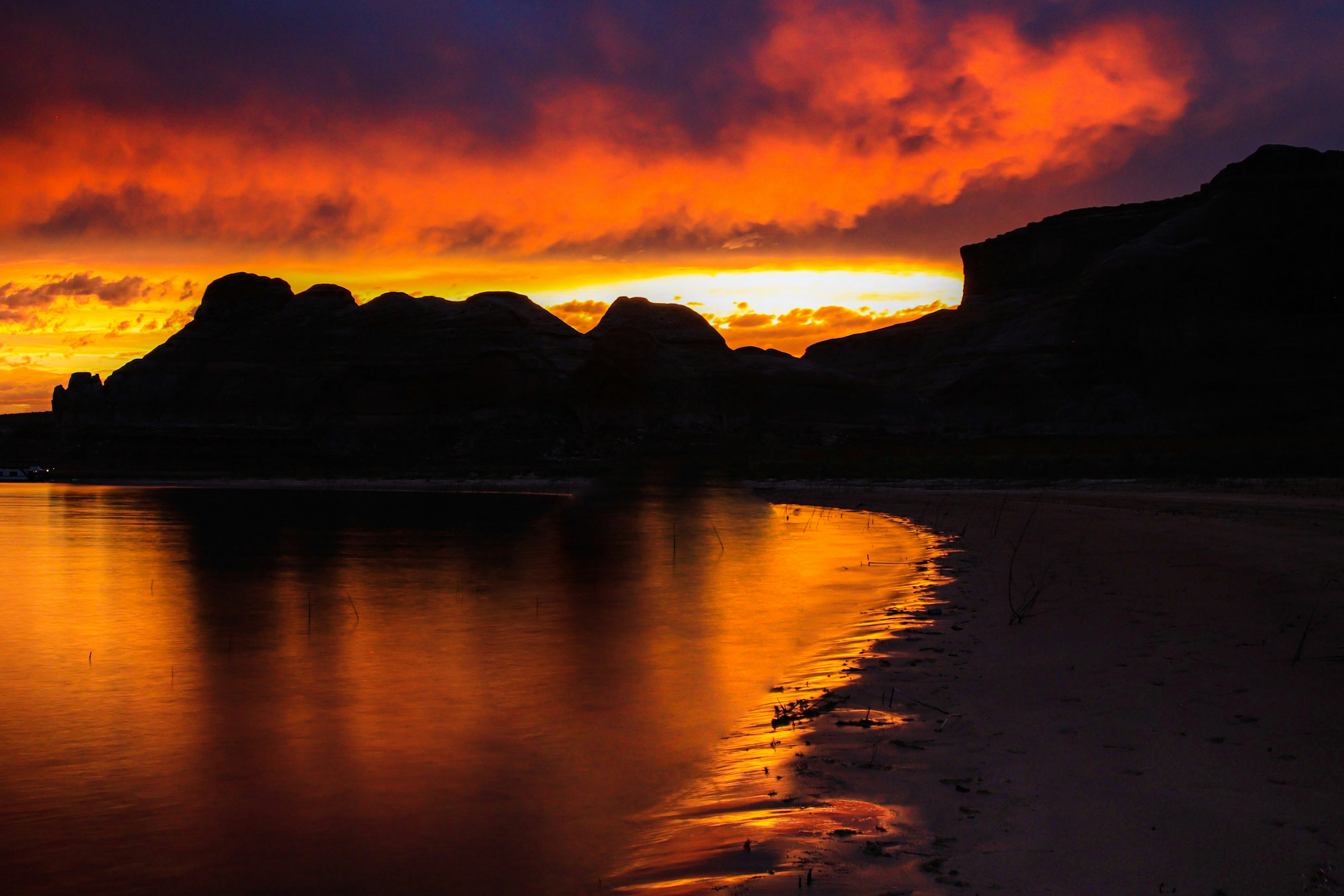 Crimson Shoreline at Dusk: Silhouetted Cliffs Meeting Golden Tide