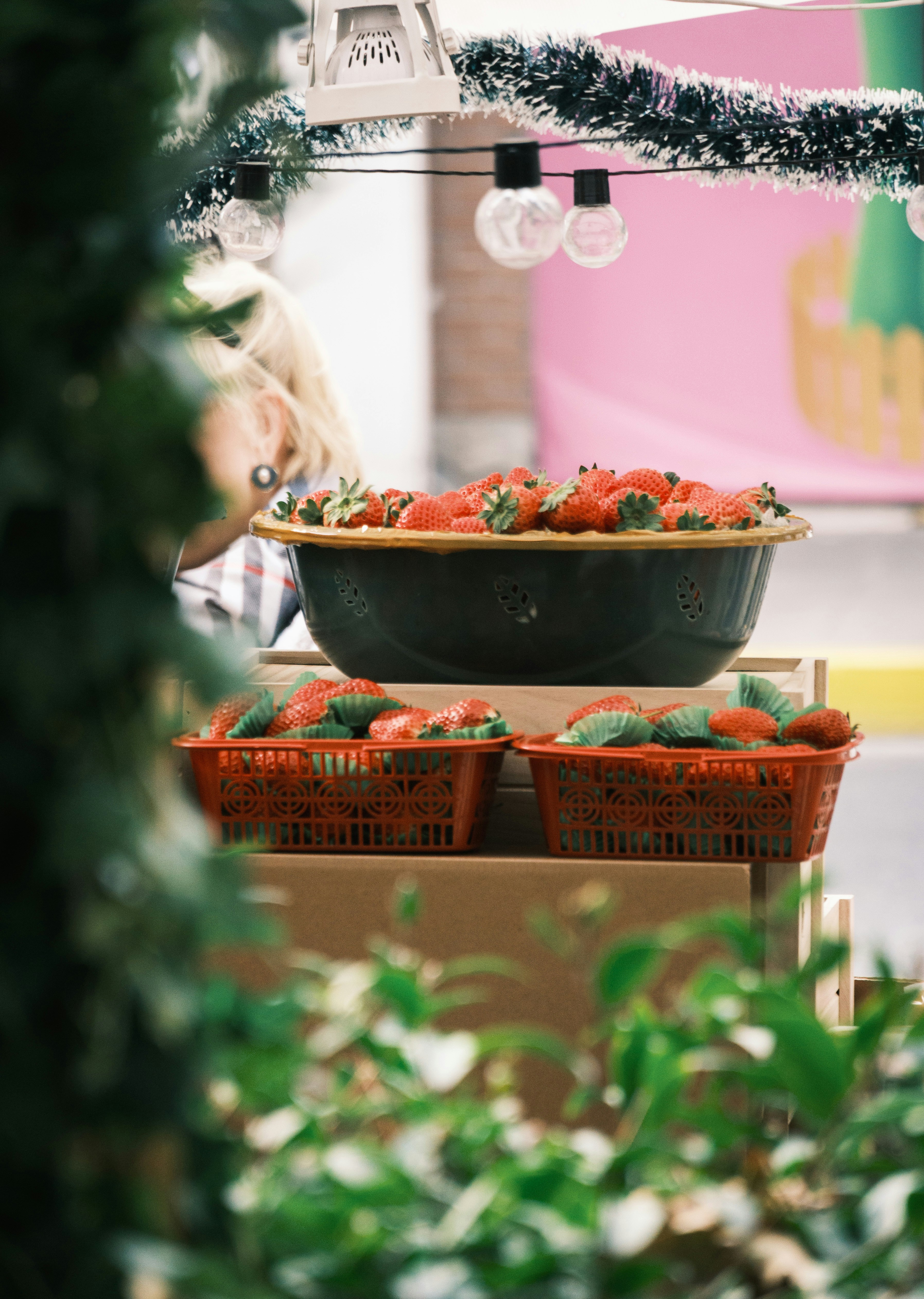 Strawberry harvest on a market stall under festive lights