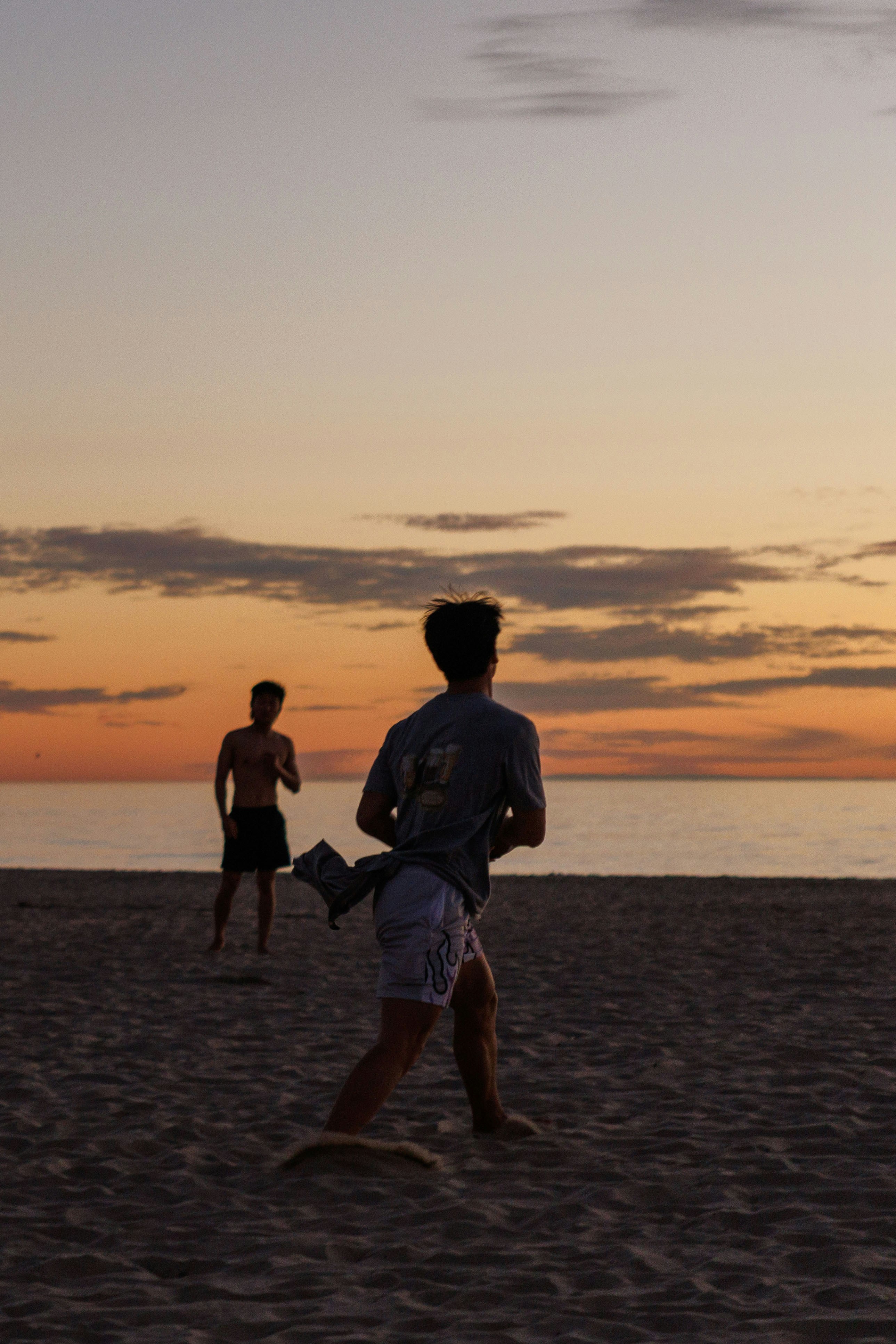 Two Silhouettes on Sunset Beach: a Quiet Duel at Dusk