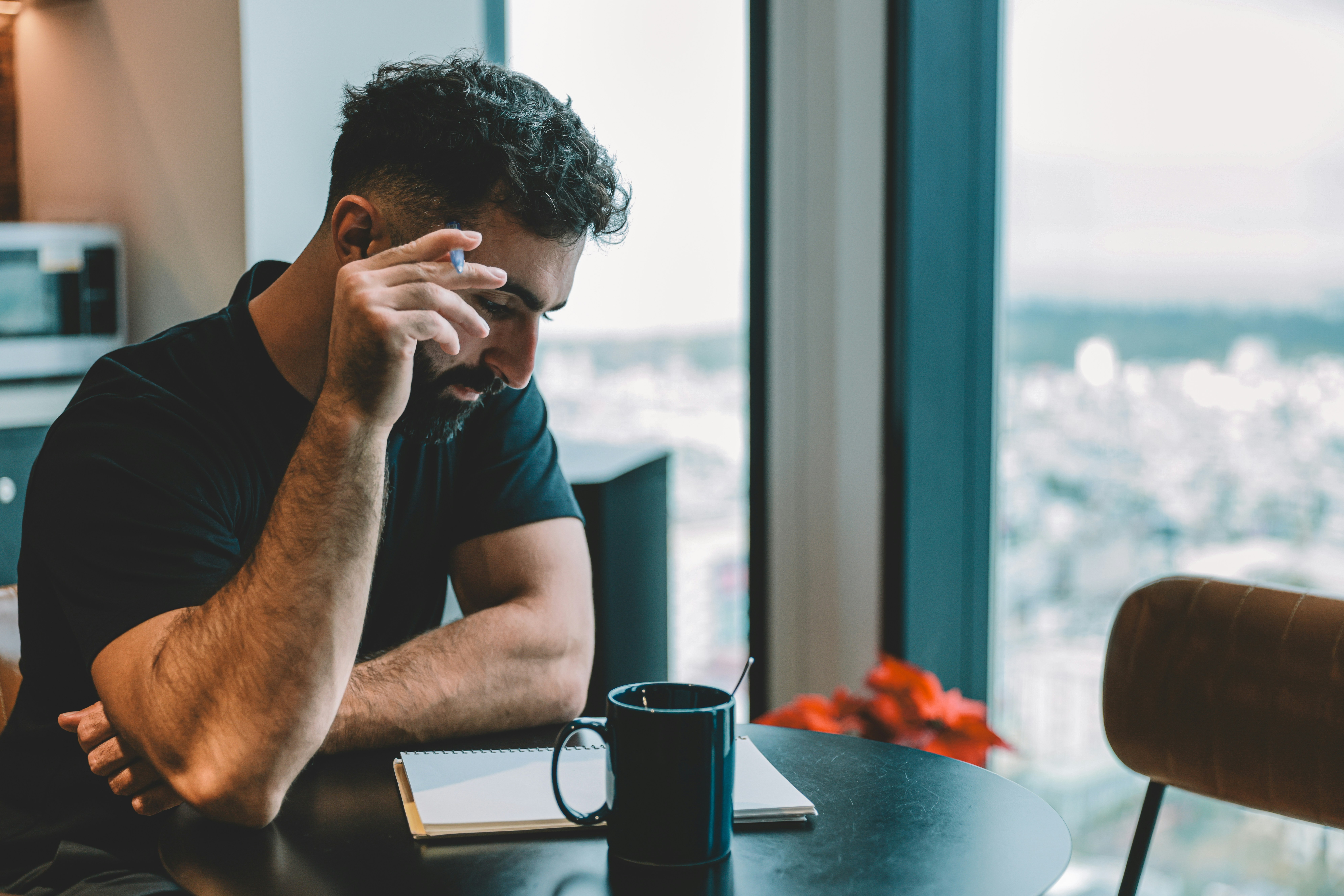 Quiet Thought in a City View: A Moment of Focus at the Workspace Window