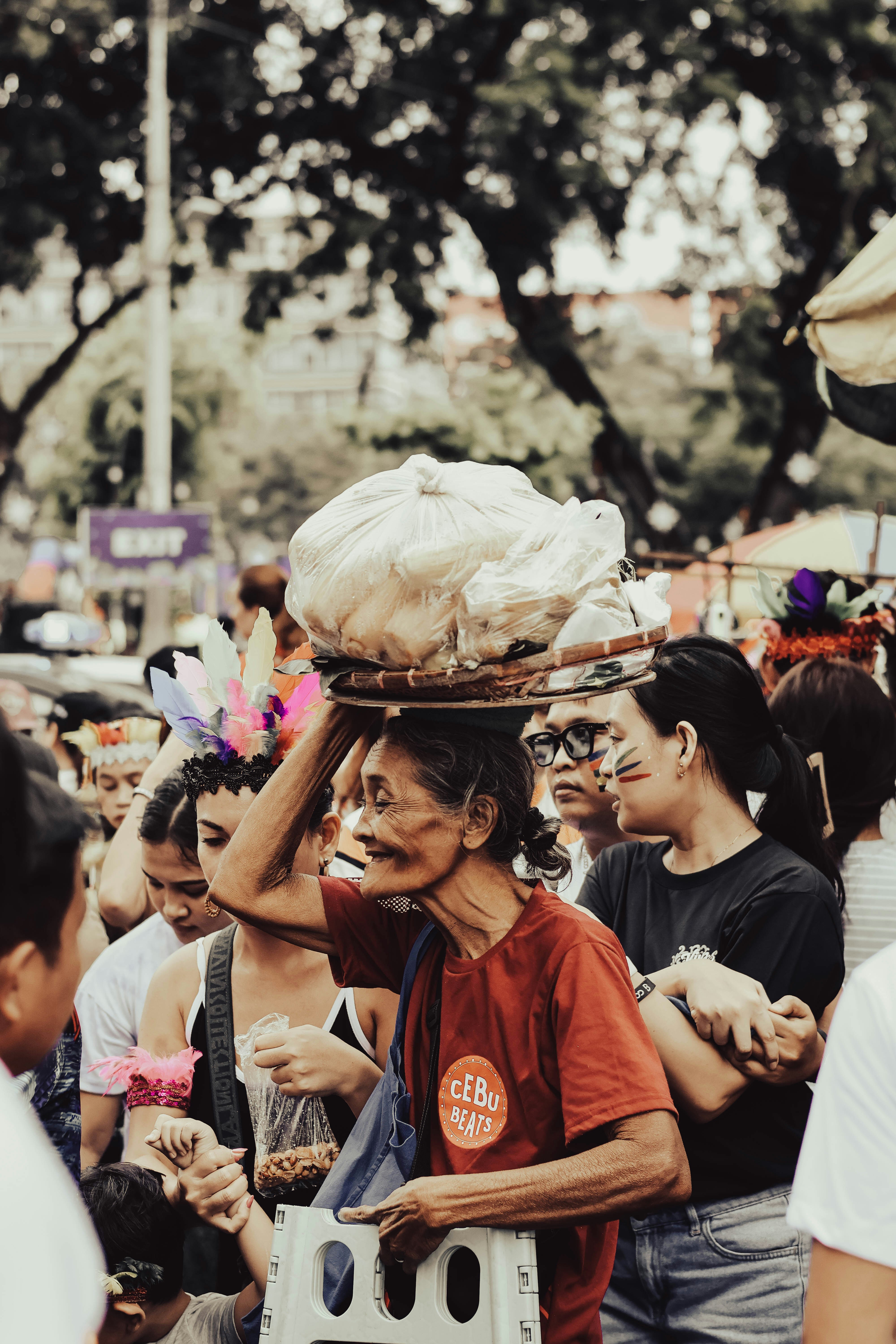 Carrier of the crowd: a matriarch balances a basket in a festival queue