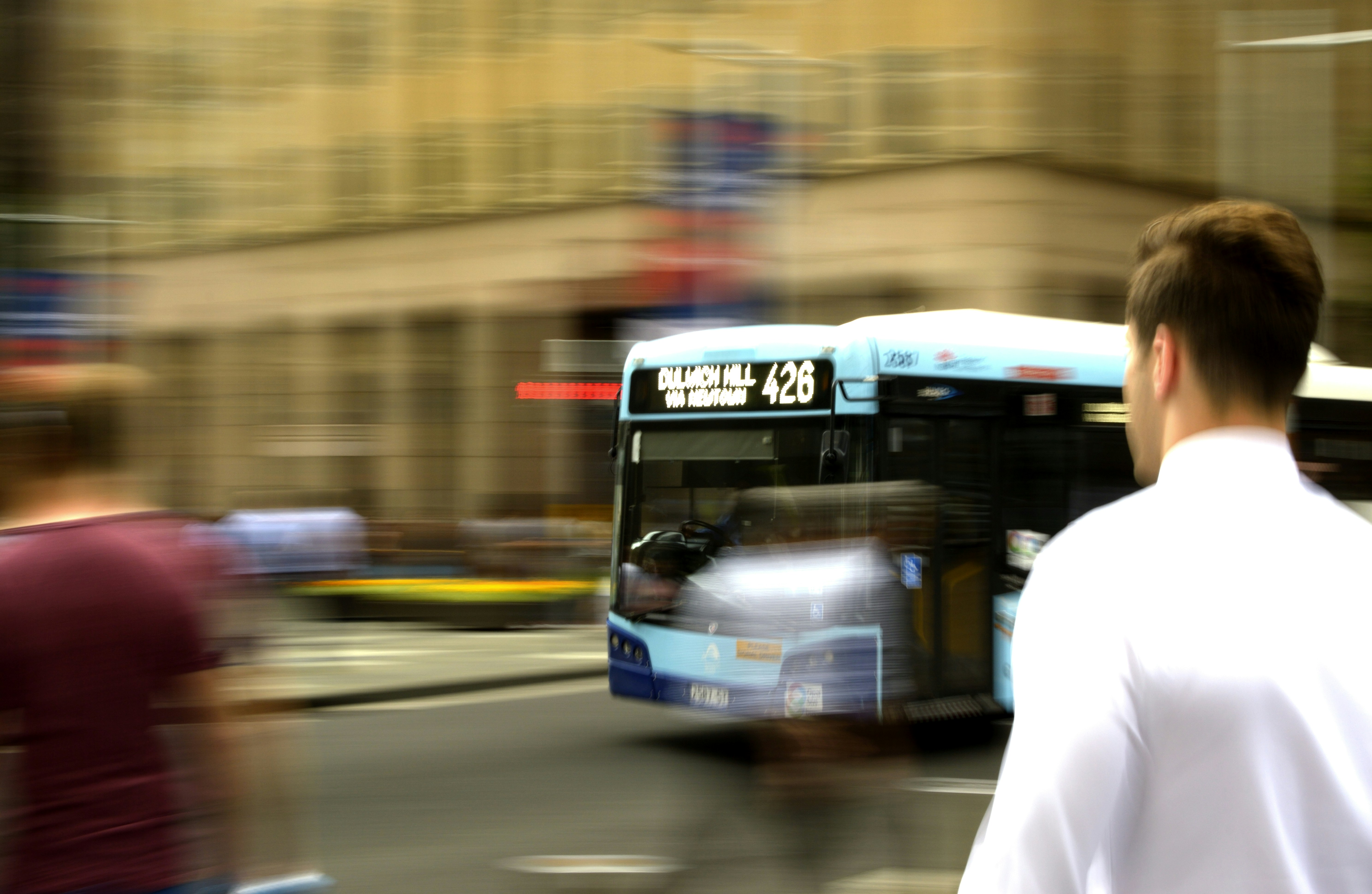 A bus moves quickly through a blurred city street. photo – Free Travel ...