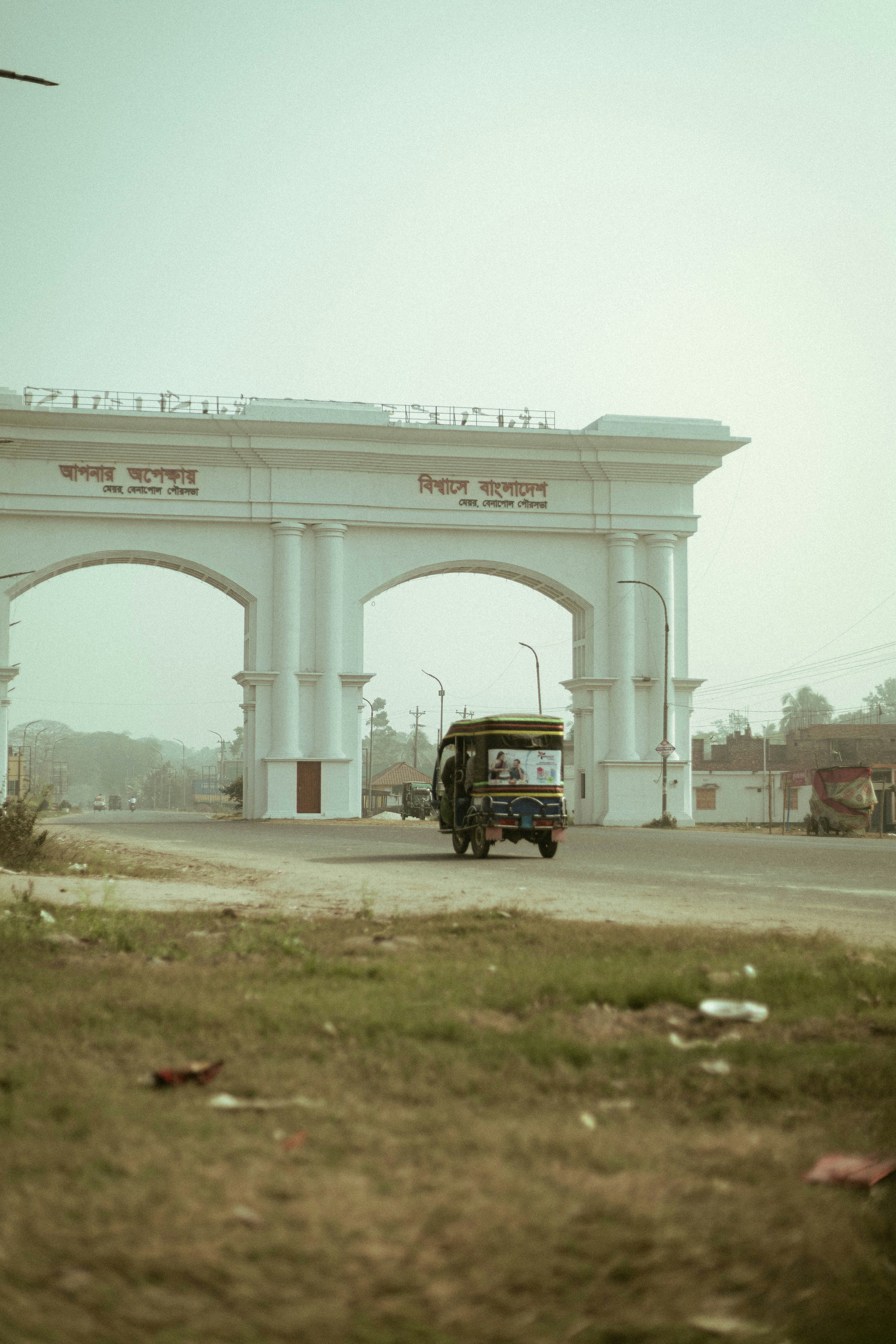 Gateway to the Dusty Dawn: A Street Scene Under an Arch