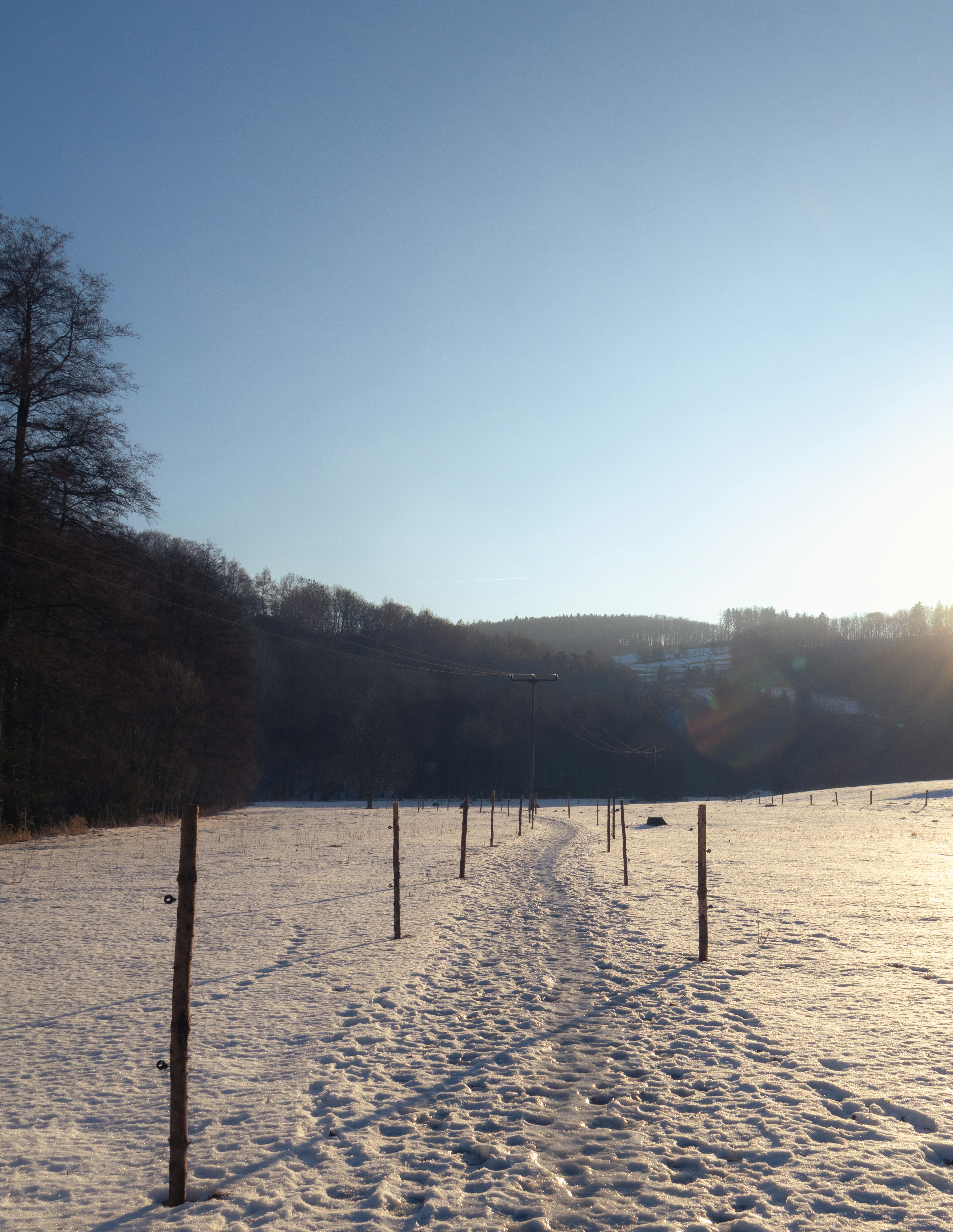 Snowlit Path Through a Quiet Field Under a Low Winter Sun