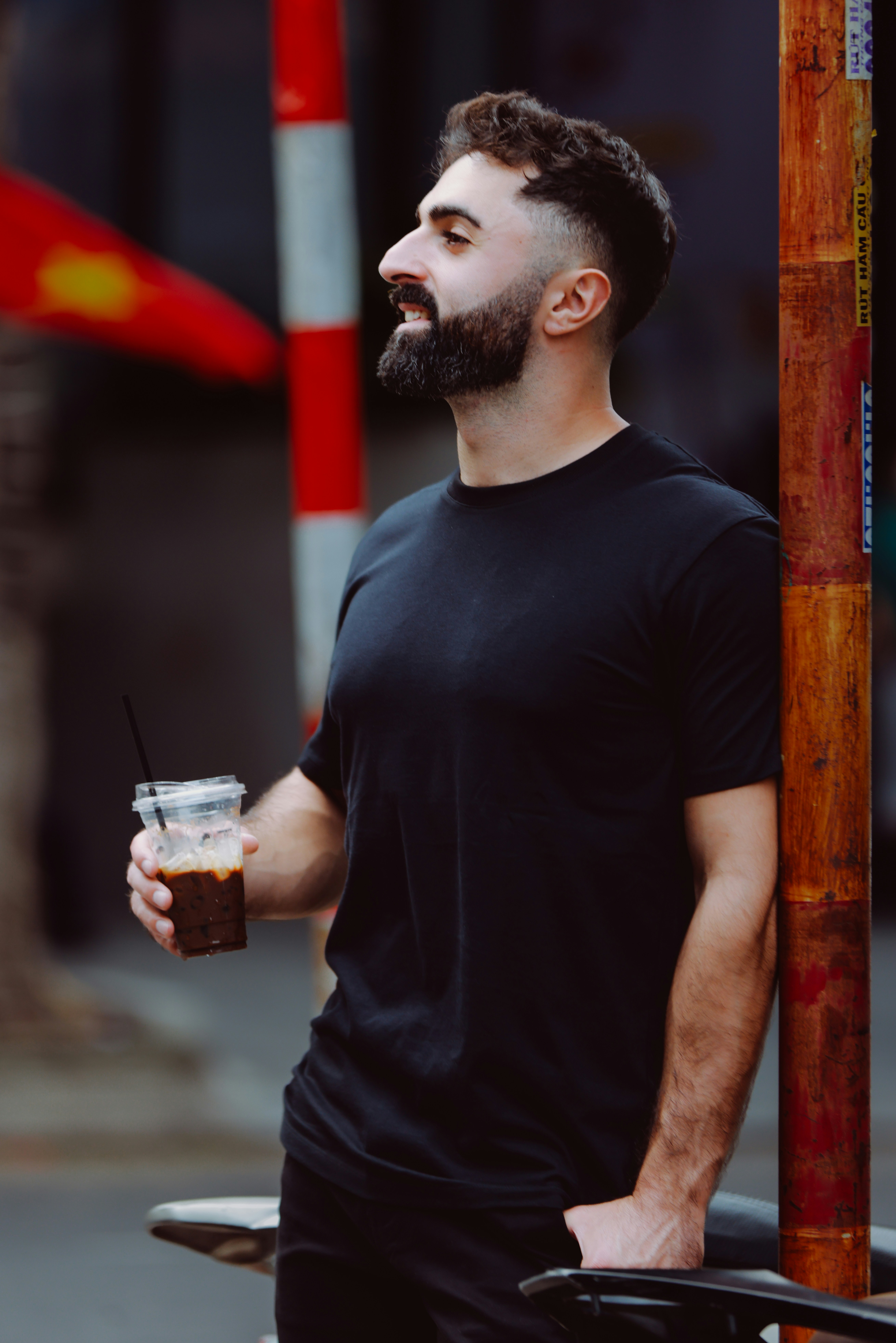 Portrait of Quiet Confidence: A Bearded Moment at the Street Pole