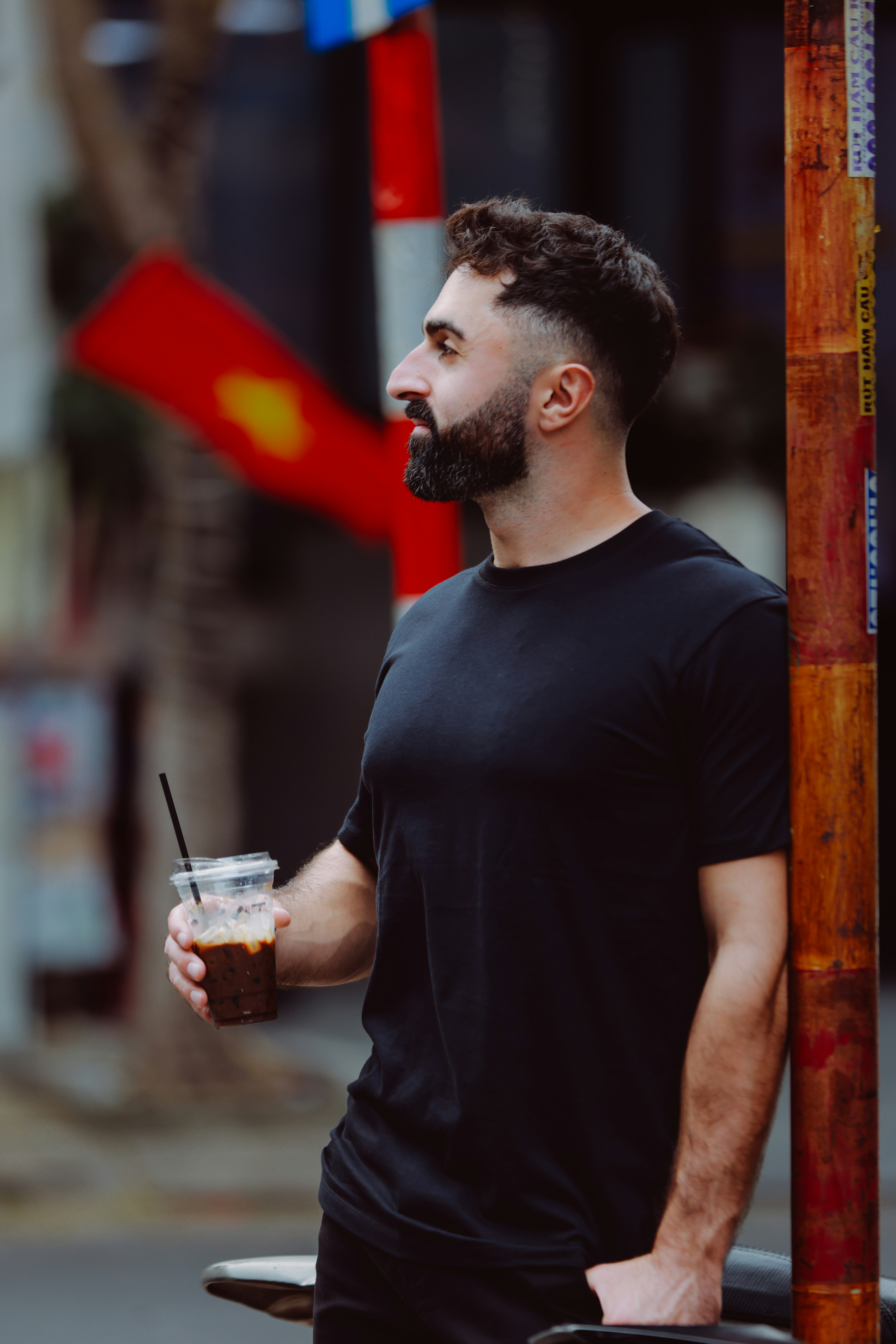 Urban café confidant: a bearded man in shadowed daylight