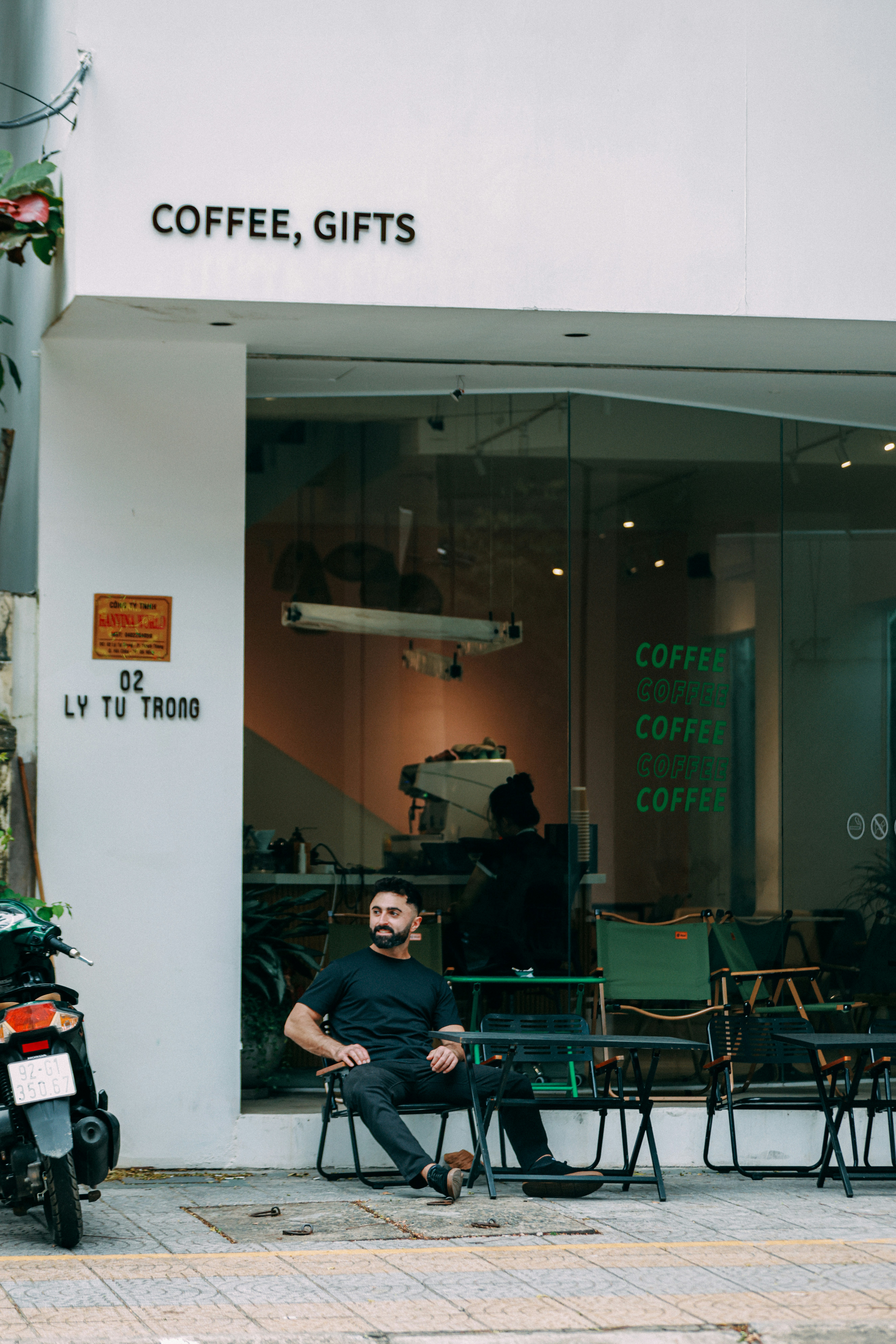Cafe-side Portrait: A man in shadowed doorway at Coffee, Gifts