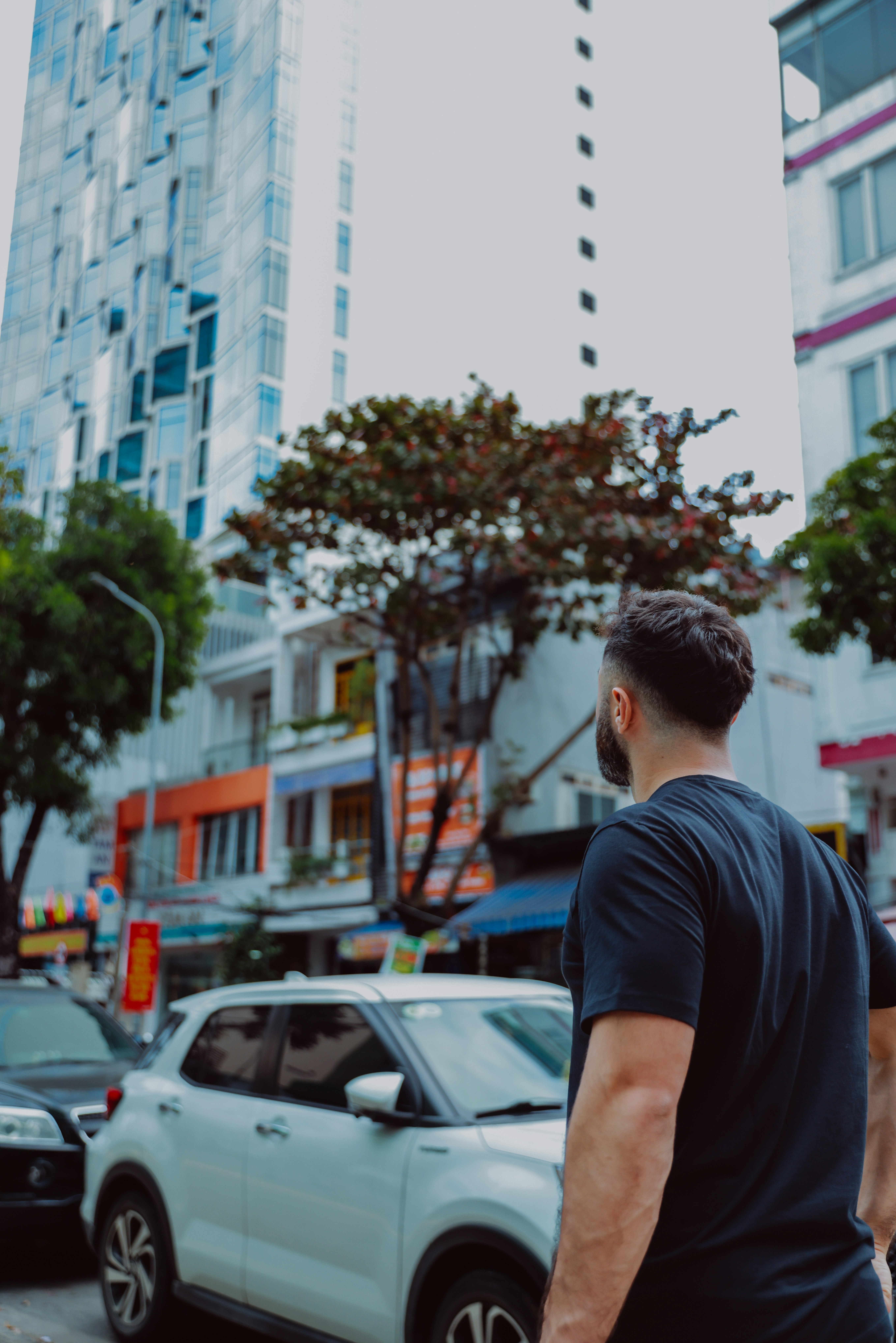 Urban silhouette: man with back turned amid city bustle