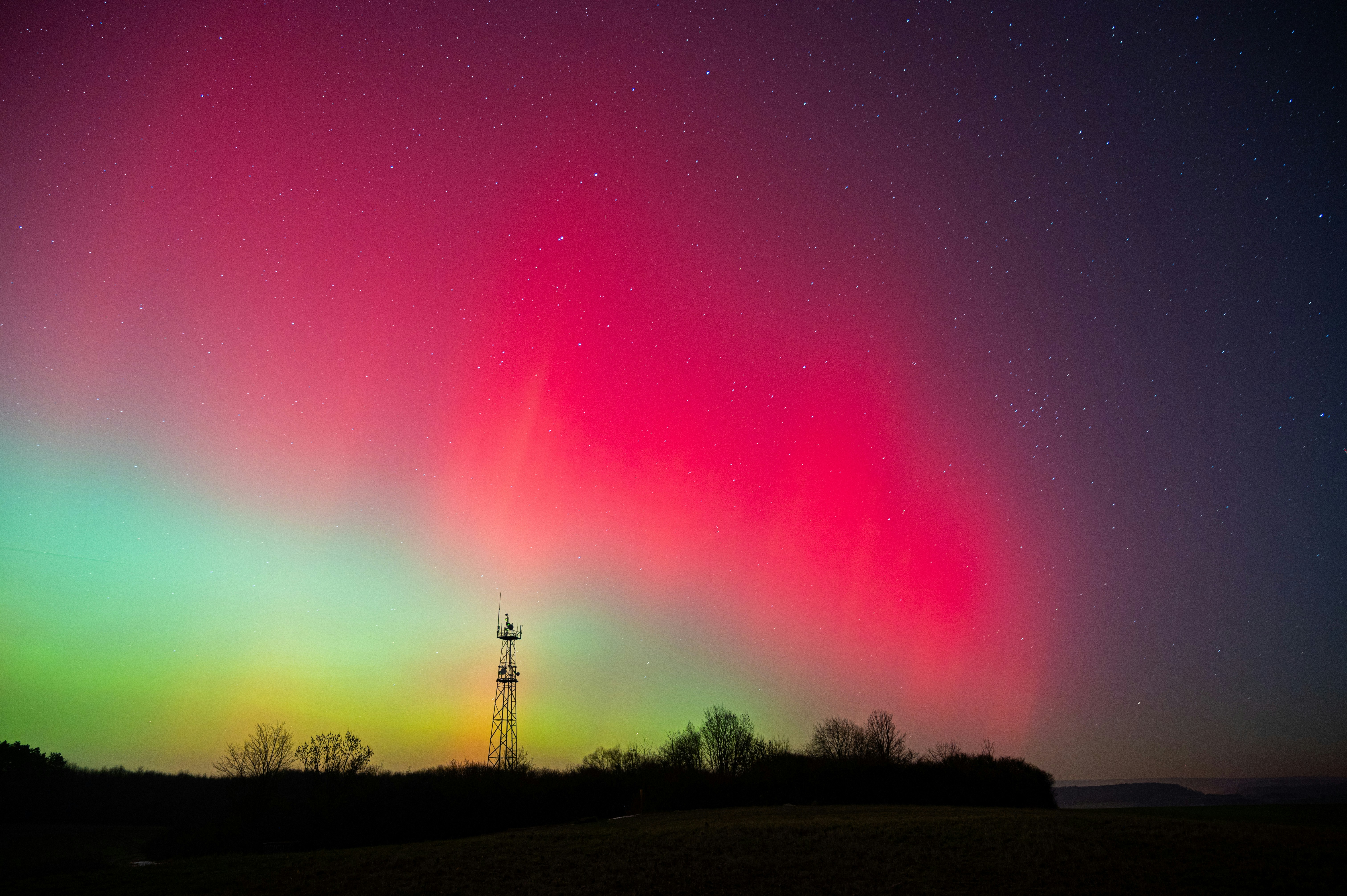 Aurora over a Silent Horizon: Green, Pink, and Night Sky