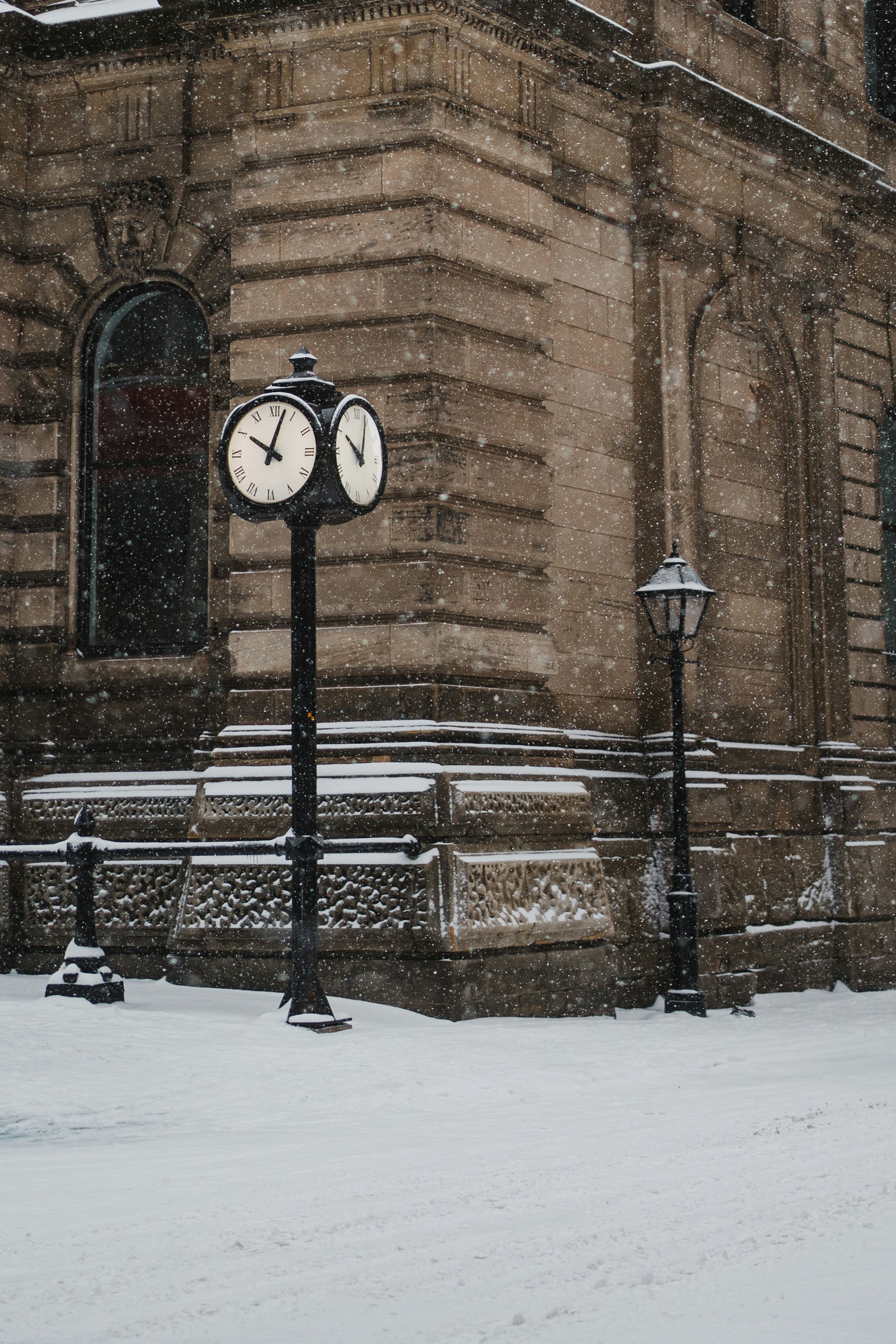 Snowfall at the Clock: Street Corner at Dusk