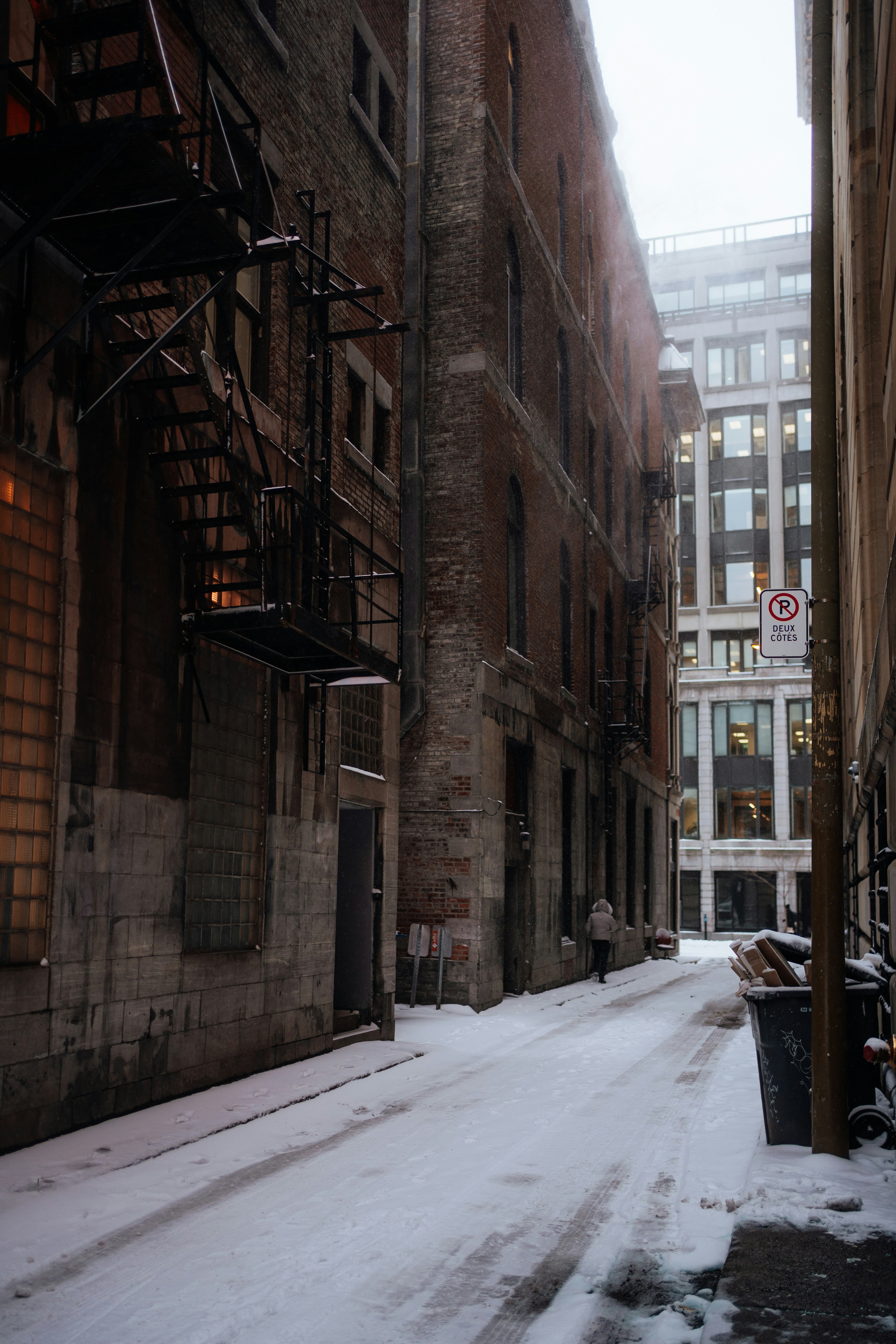 Snowy alleyway between brick buildings in a city. photo – Free ...