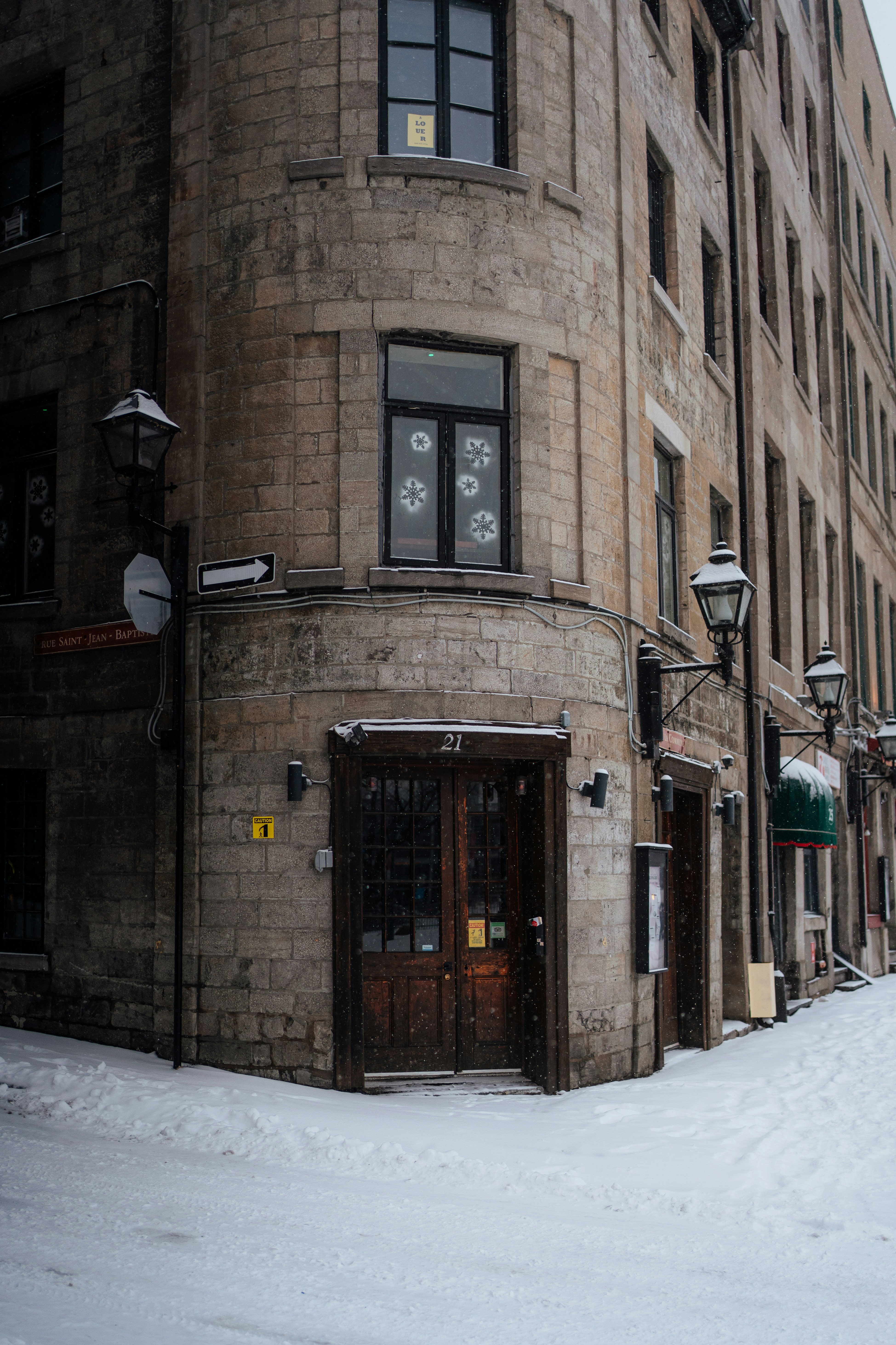 Snowbound Stone Facade: A Corner Café in Winter Light