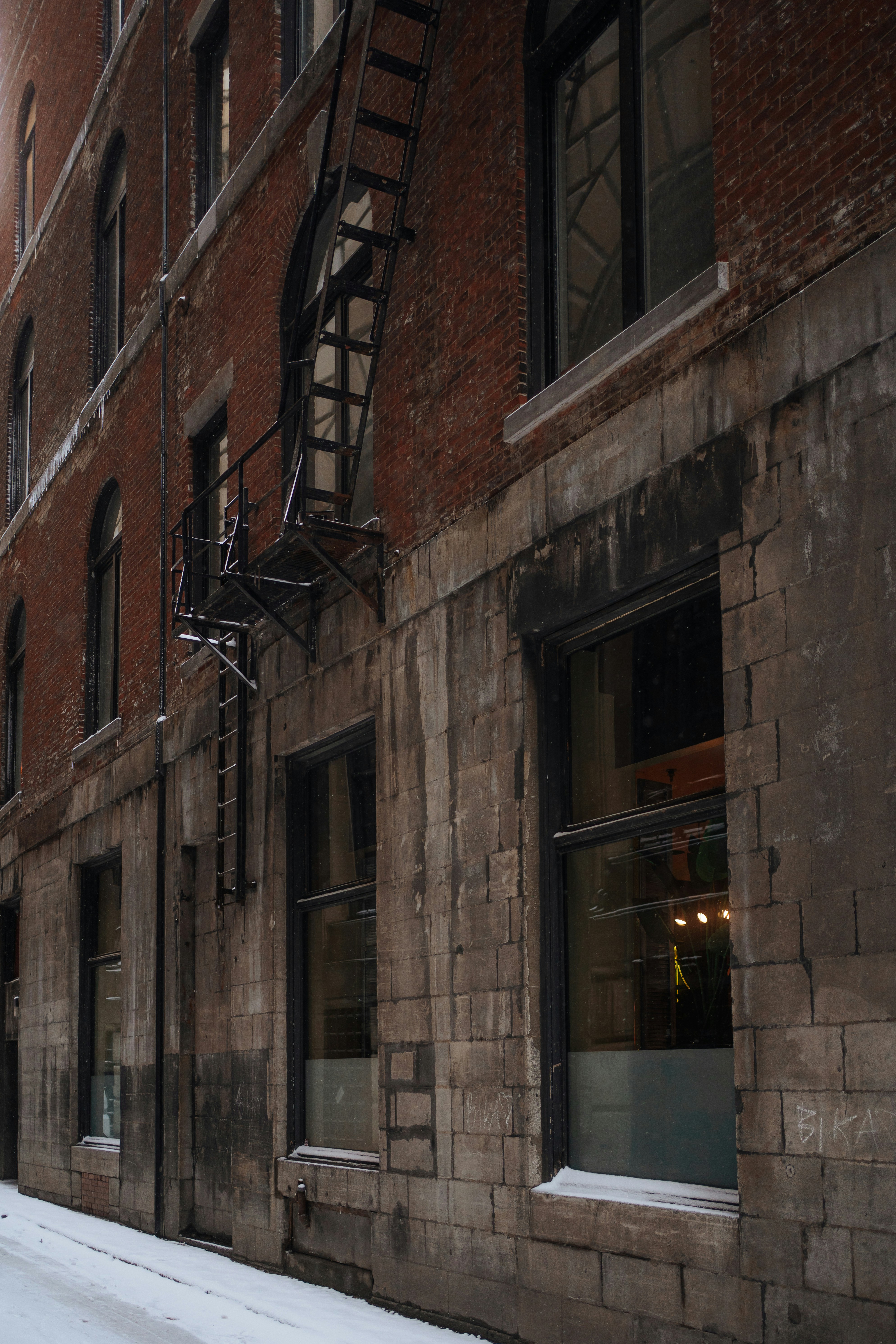 Snow on the City: Iron Fire Escape and Weathered Facade