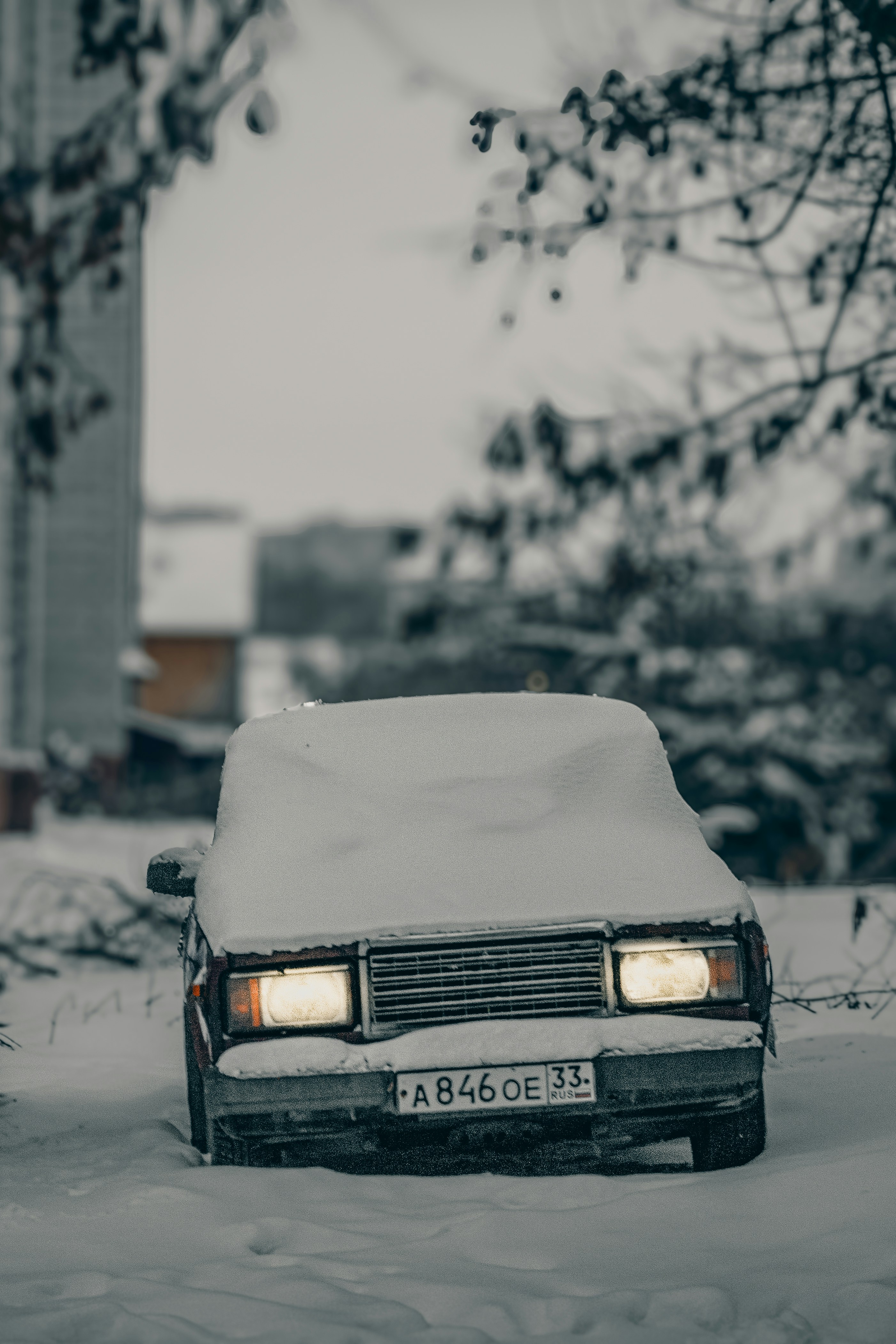 Snowbound Sedan: A Weathered Ride Emerges from the White Quiet