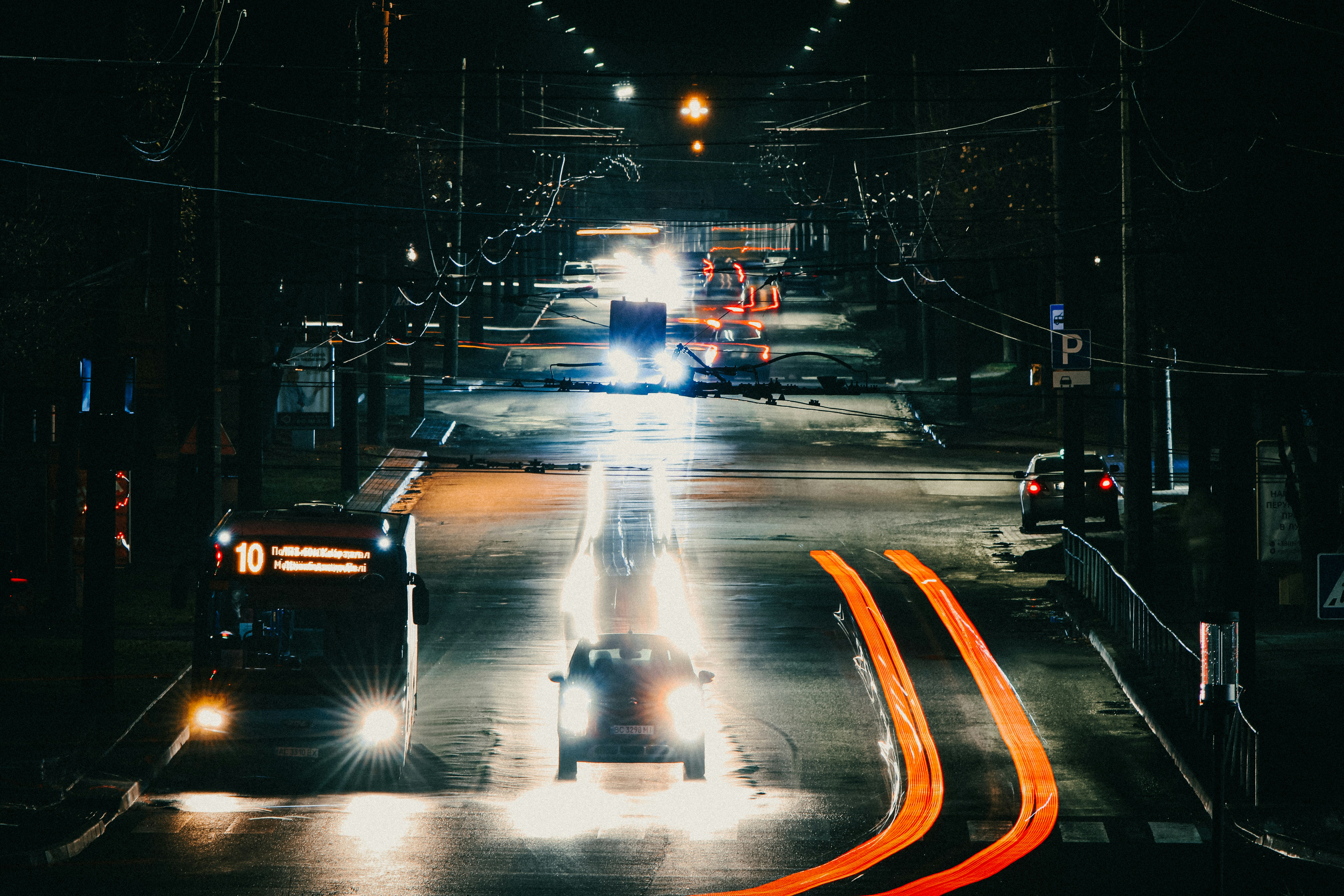Headlights on a Quiet Street: Neon Ribbons Arcing Through Night