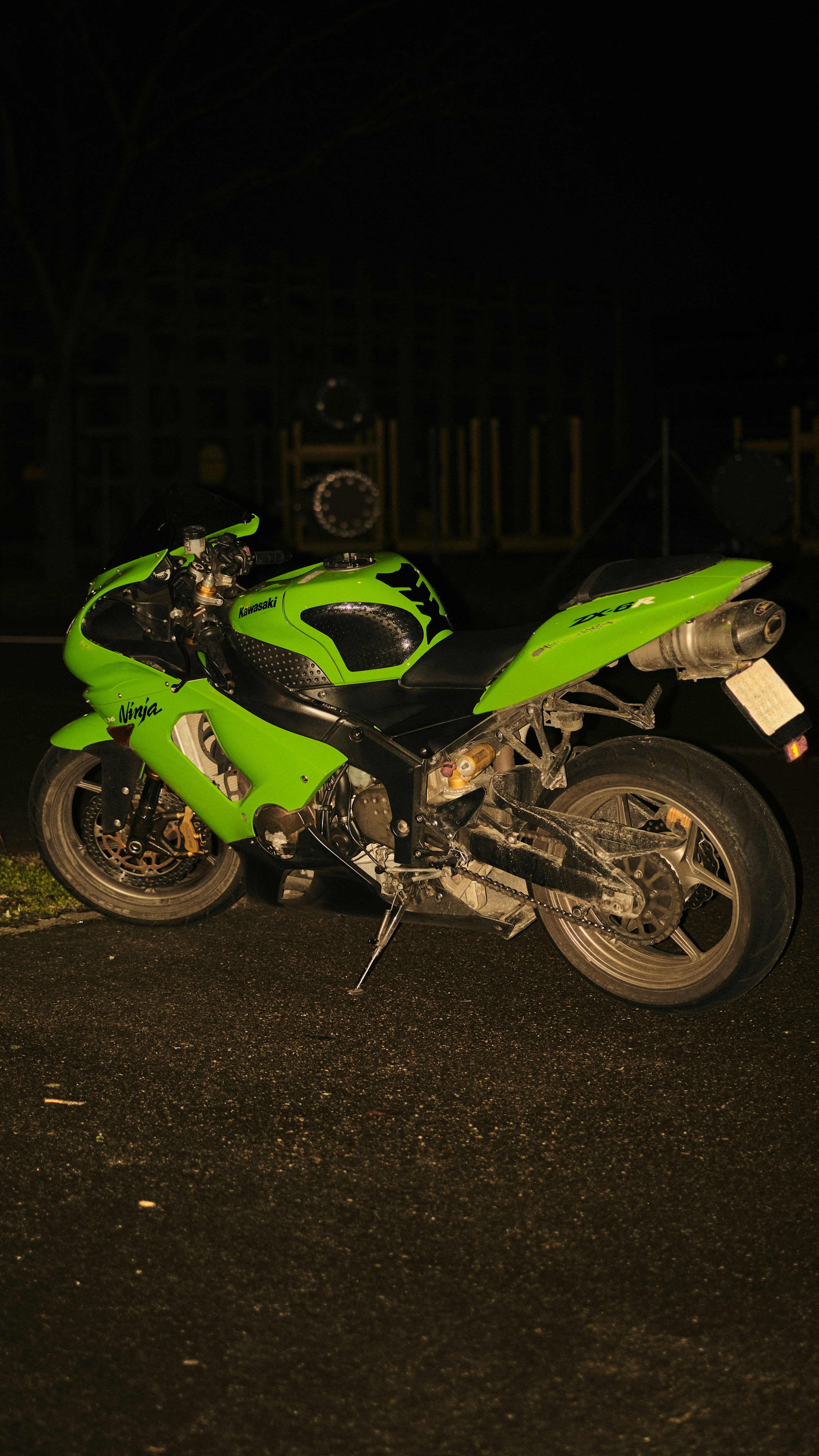 Luminous Green Kawasaki Ninja Resting Under Night Streetlights