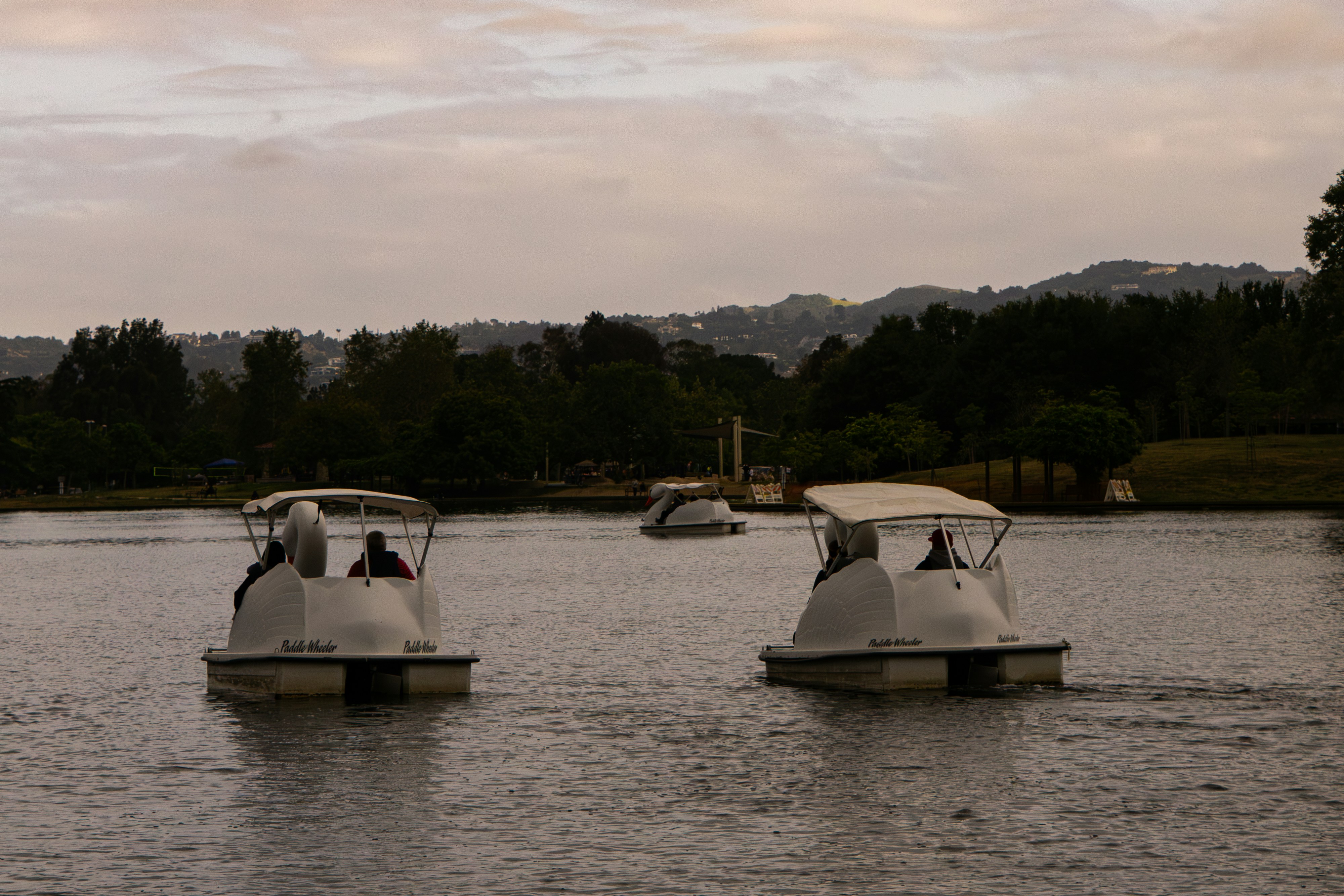 Two Boats Drifting Across a Quiet Lake at Dusk