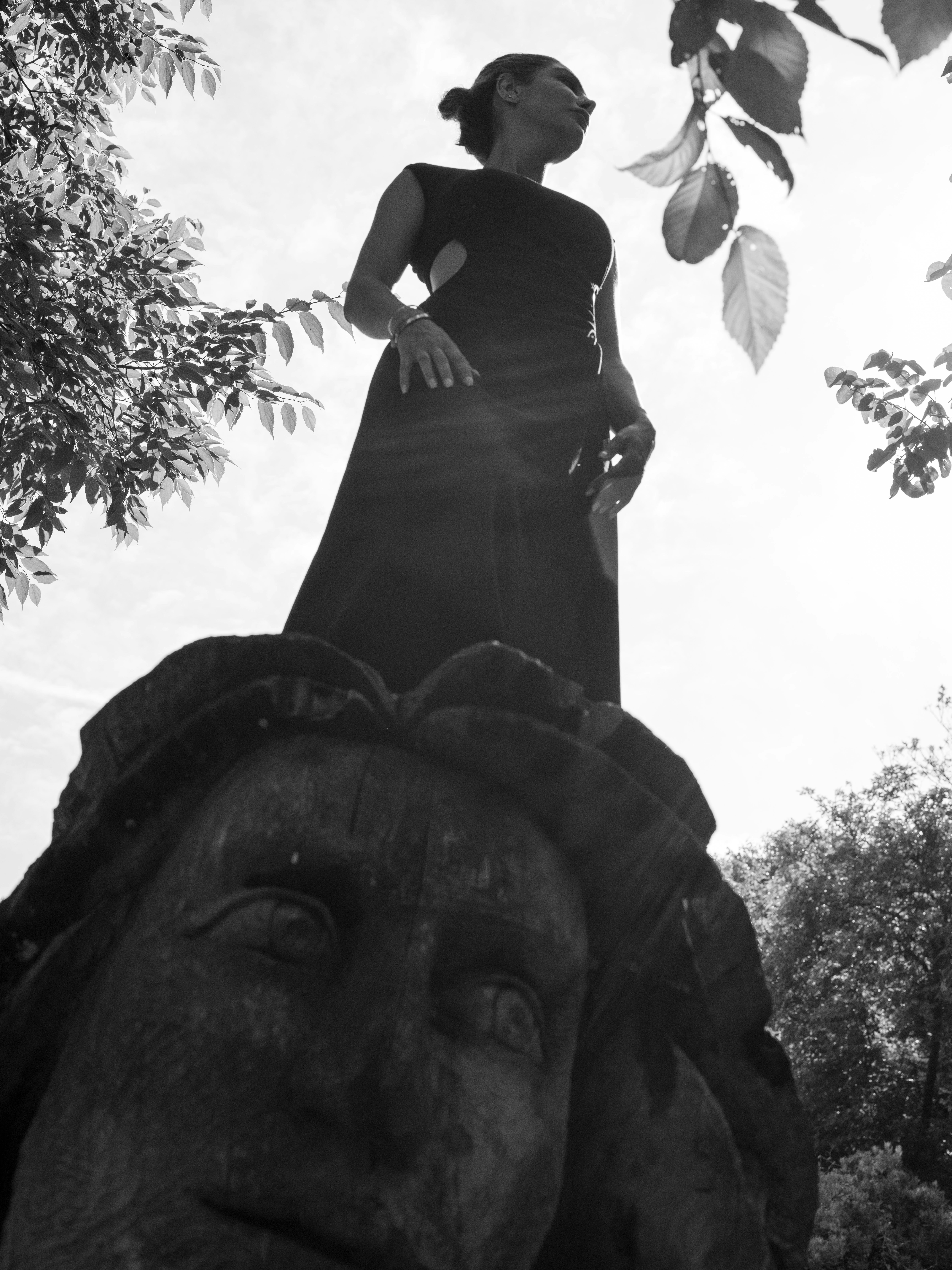 Overlooked Gaze: A Figure in Moonlit Silhouette Above a Sculpted Face