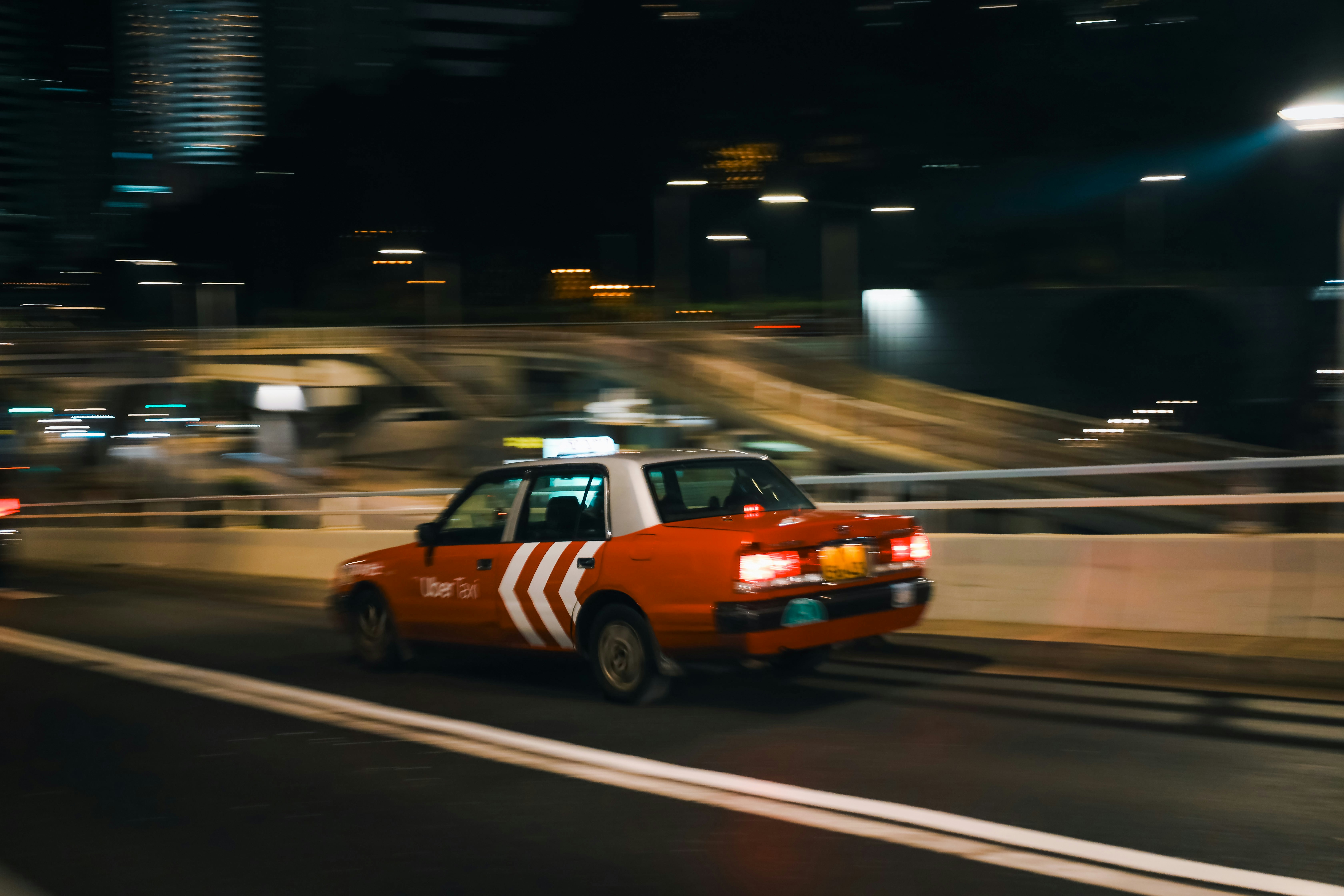 Night Street Racer: Red Taxi in Motion on a Blurred City Bridge