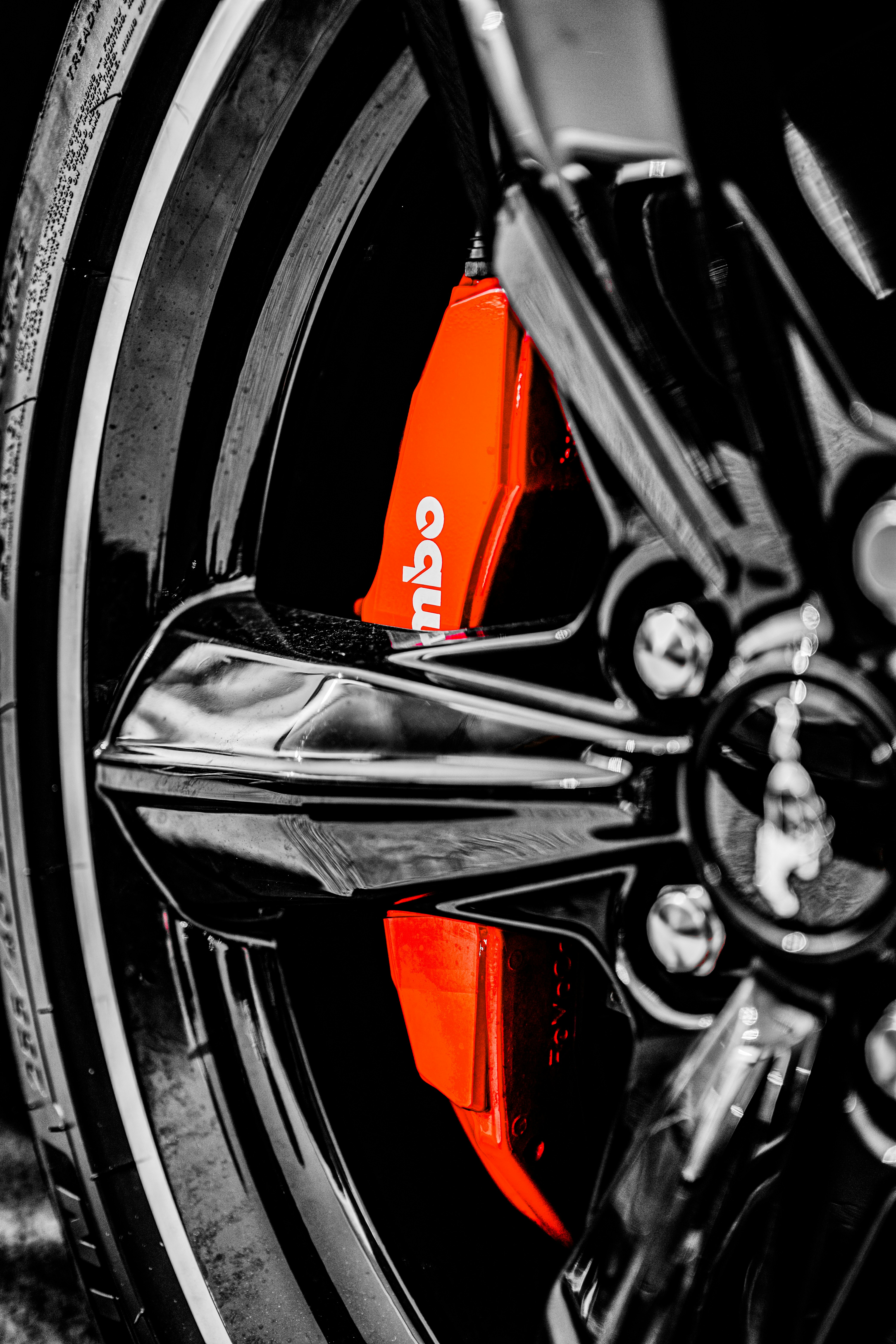 Red Breather: A Close-up on Orange Caliper through a Black Rim
